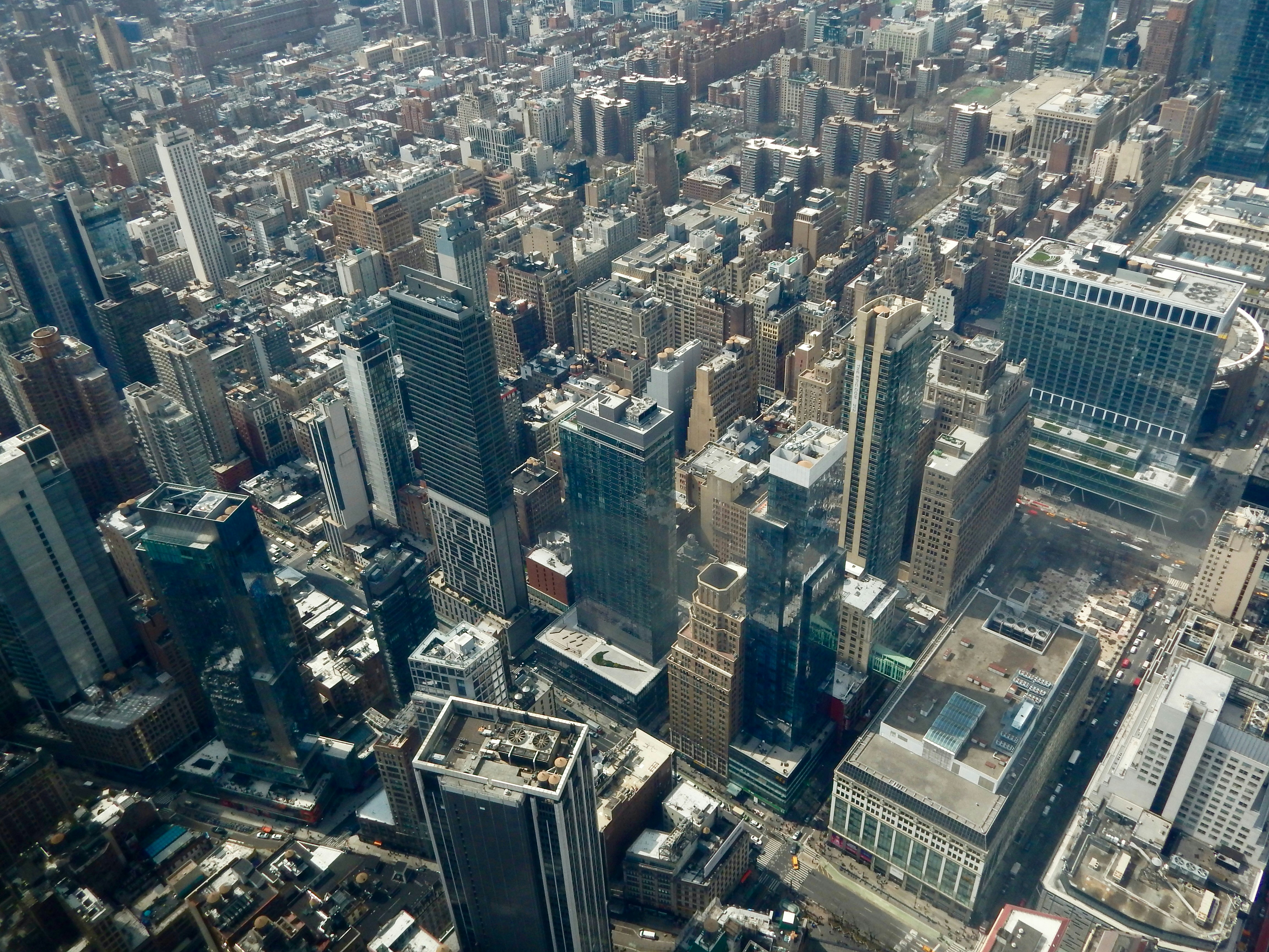 Aerial view of a densely packed cityscape with towering skyscrapers and intricate street patterns.