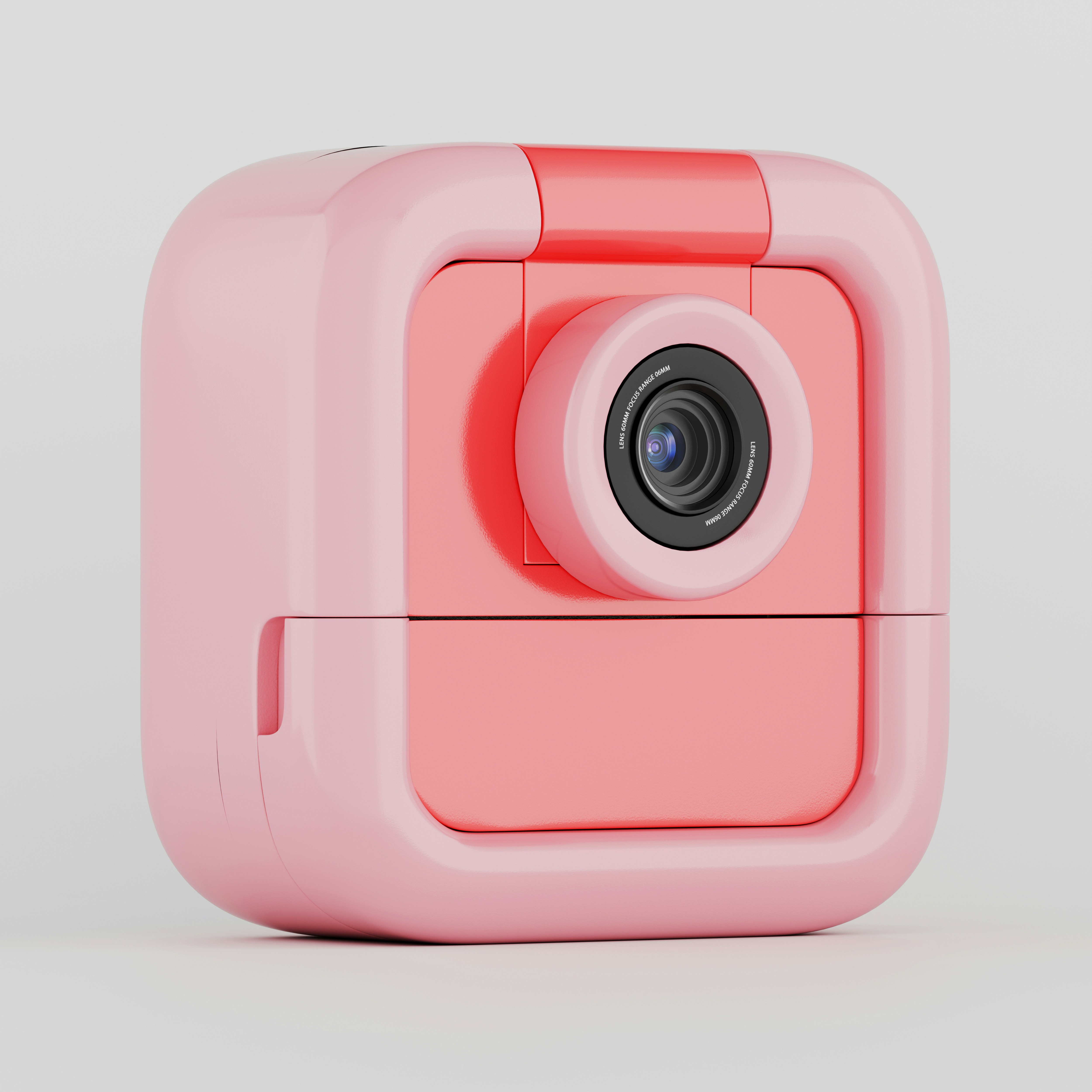 A pink cube camera is posed on a white backdrop. photo – Free Pink ...