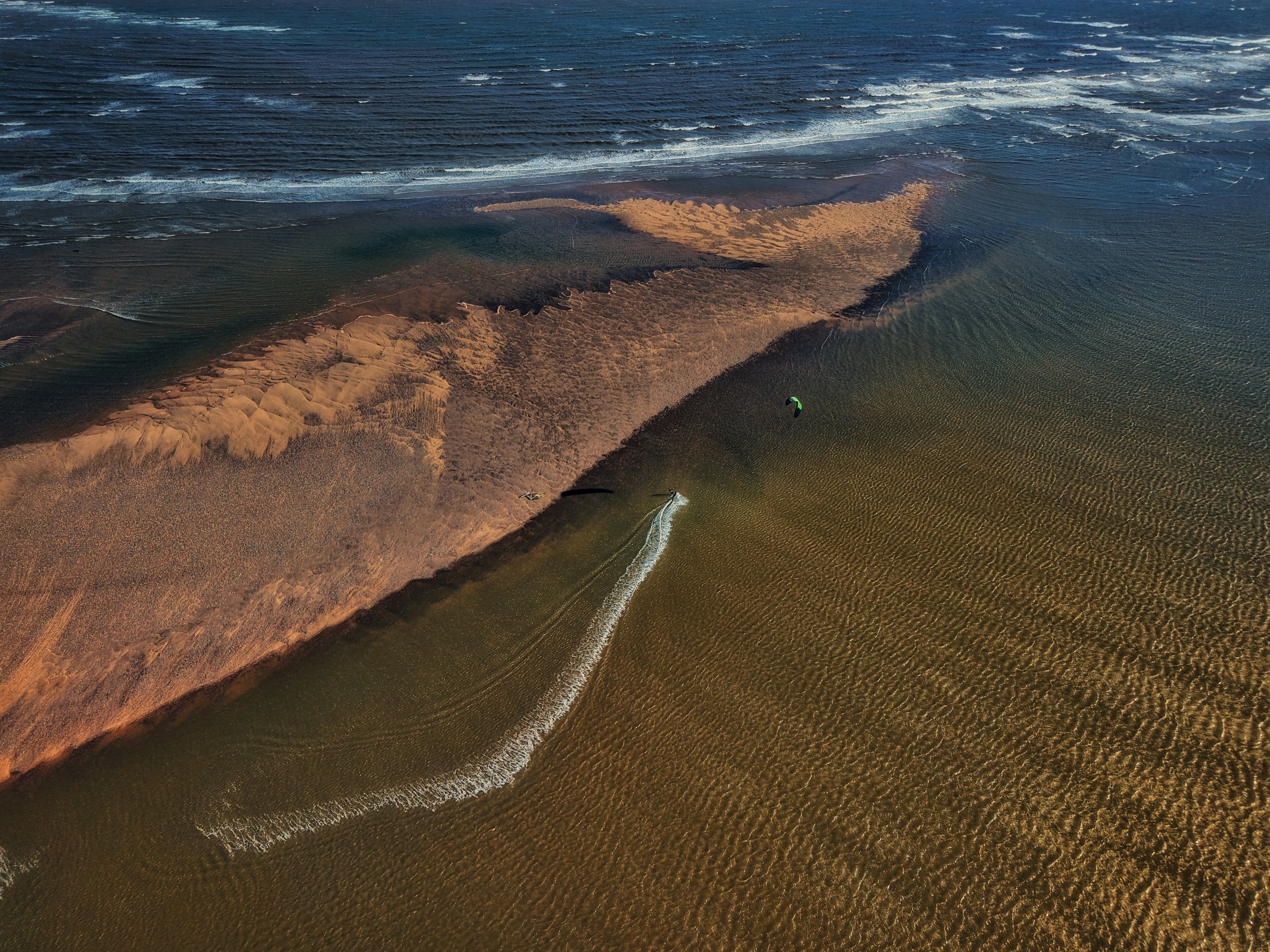 Kite surfer navigating the outer sand banks of the Exe Estuary in Devon, UK.
