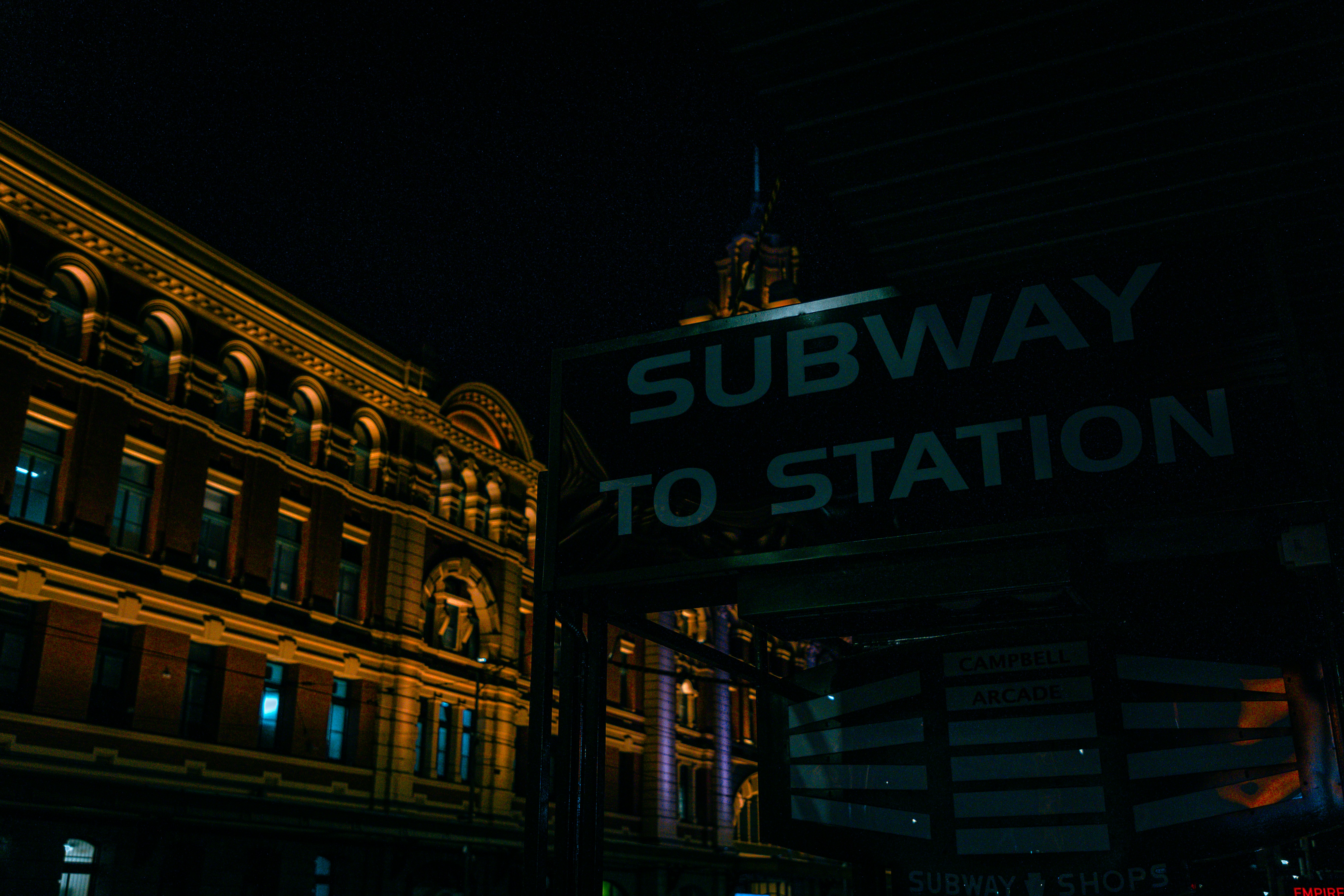 Subway sign points to a station at night. photo – Free Building Image ...