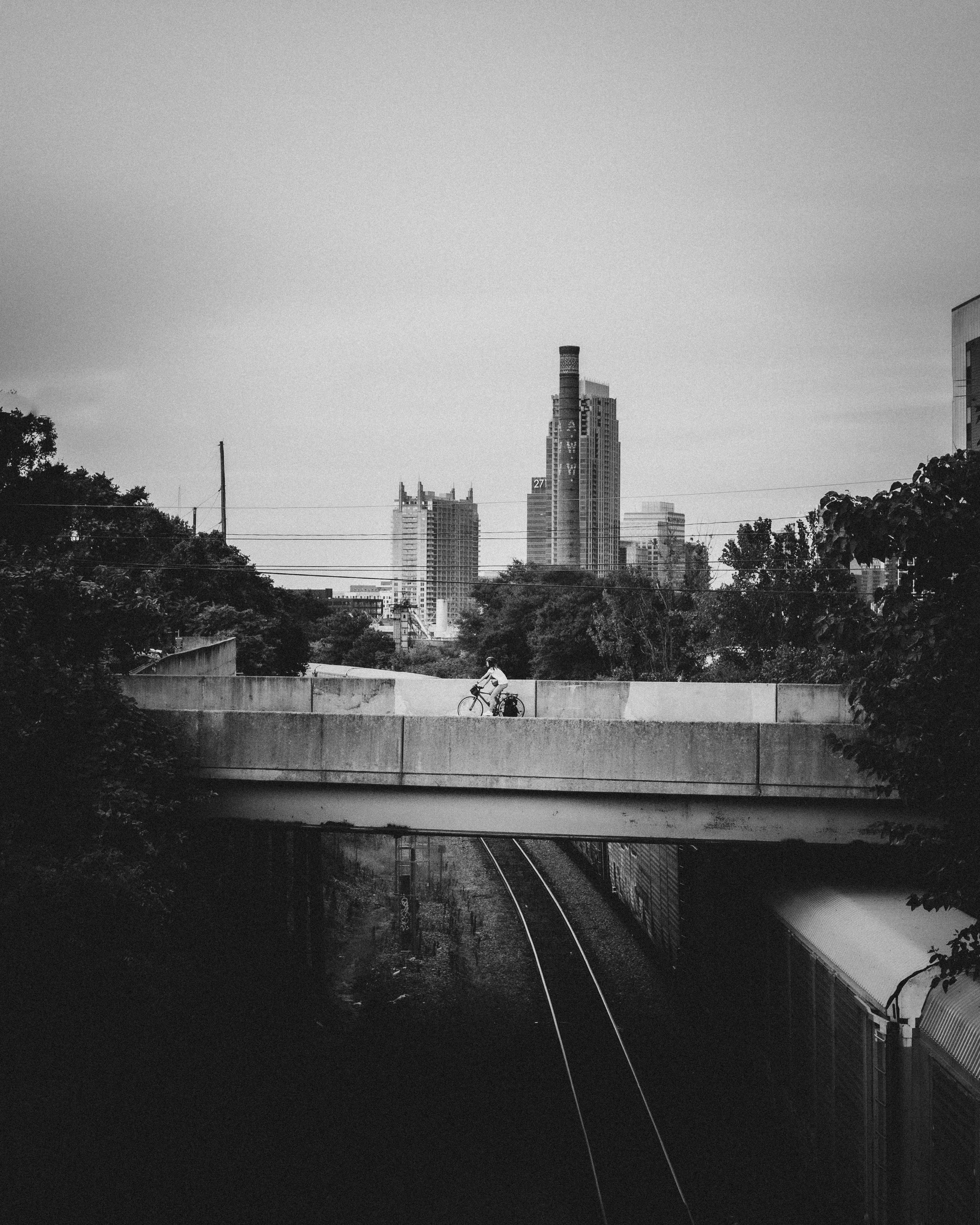 Urban Crossing: A Rider on the Bridge Over Rails