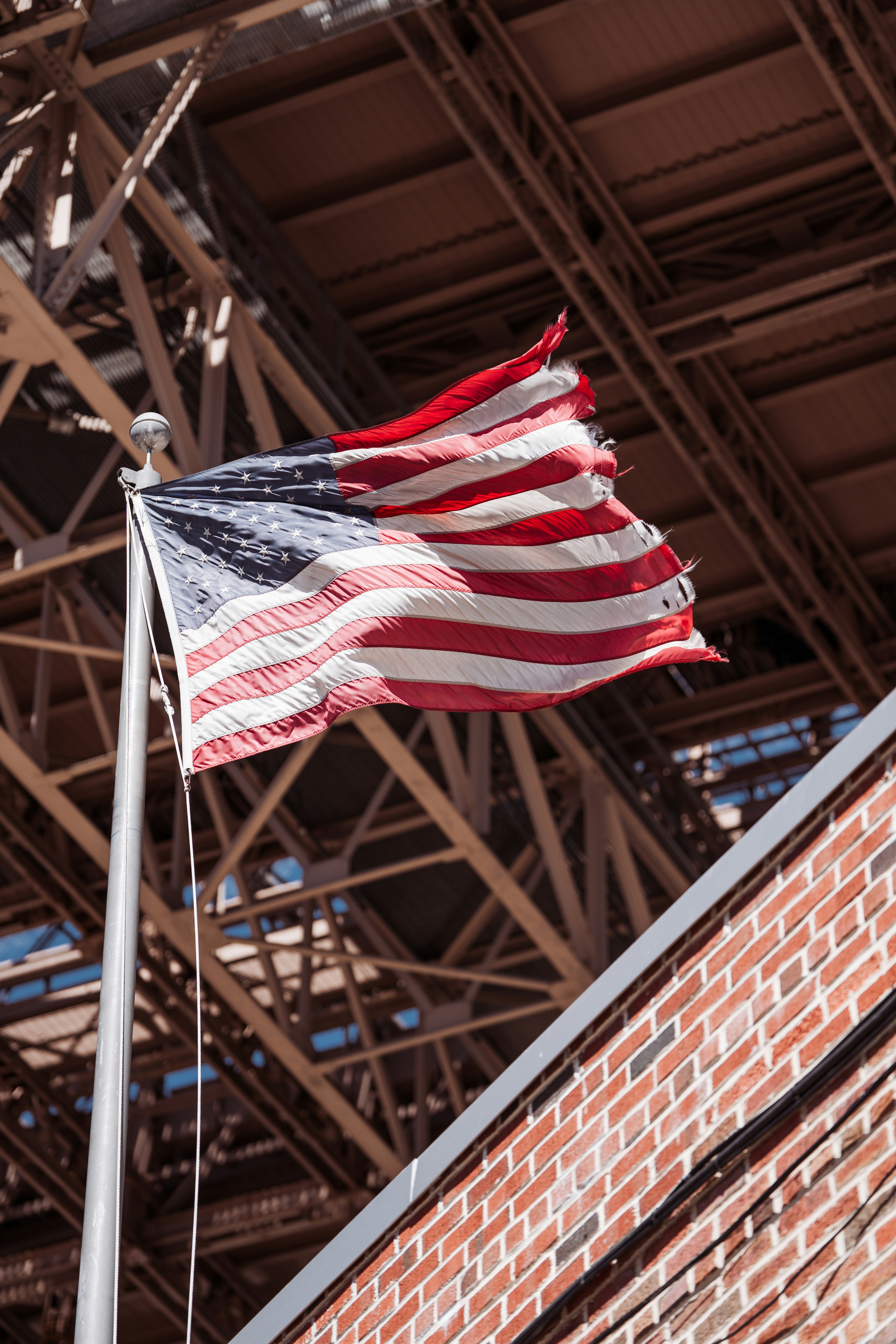 Windswept Stars and Stripes Against Industrial Steel