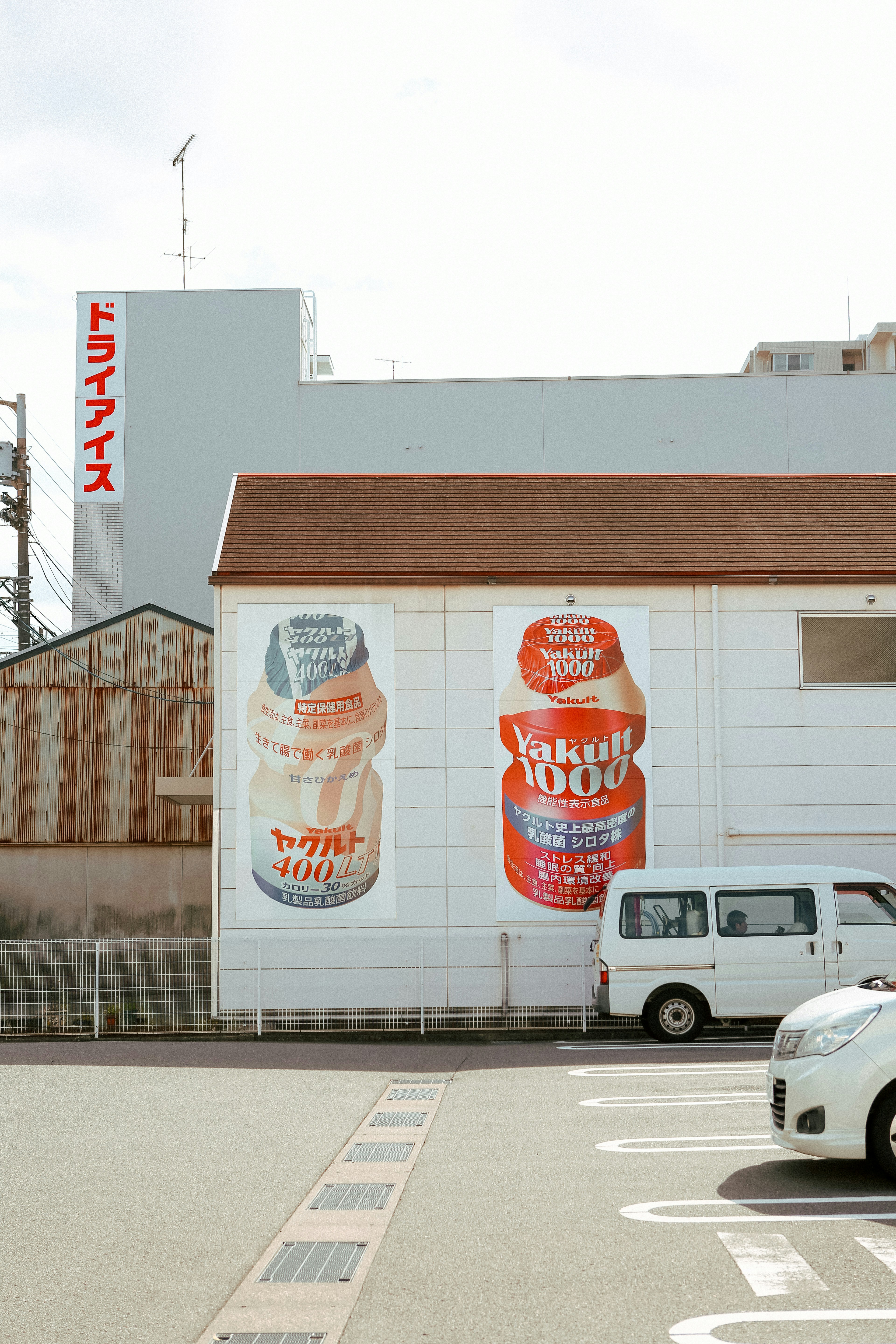 Yakult posters adorn a white building in japan. photo – Free Street ...
