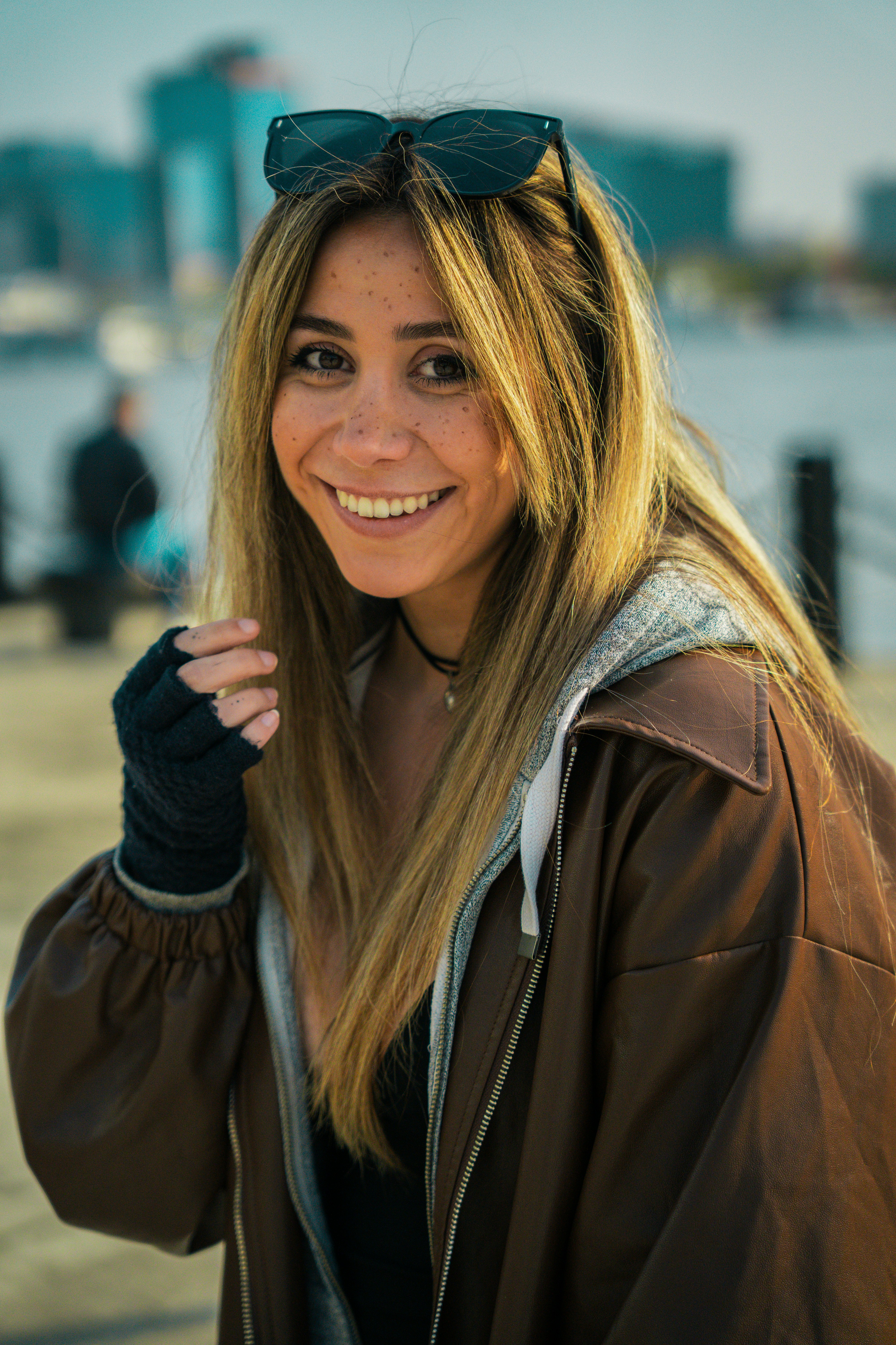 A smiling woman poses outdoors near the water. photo – Free Woman Image ...