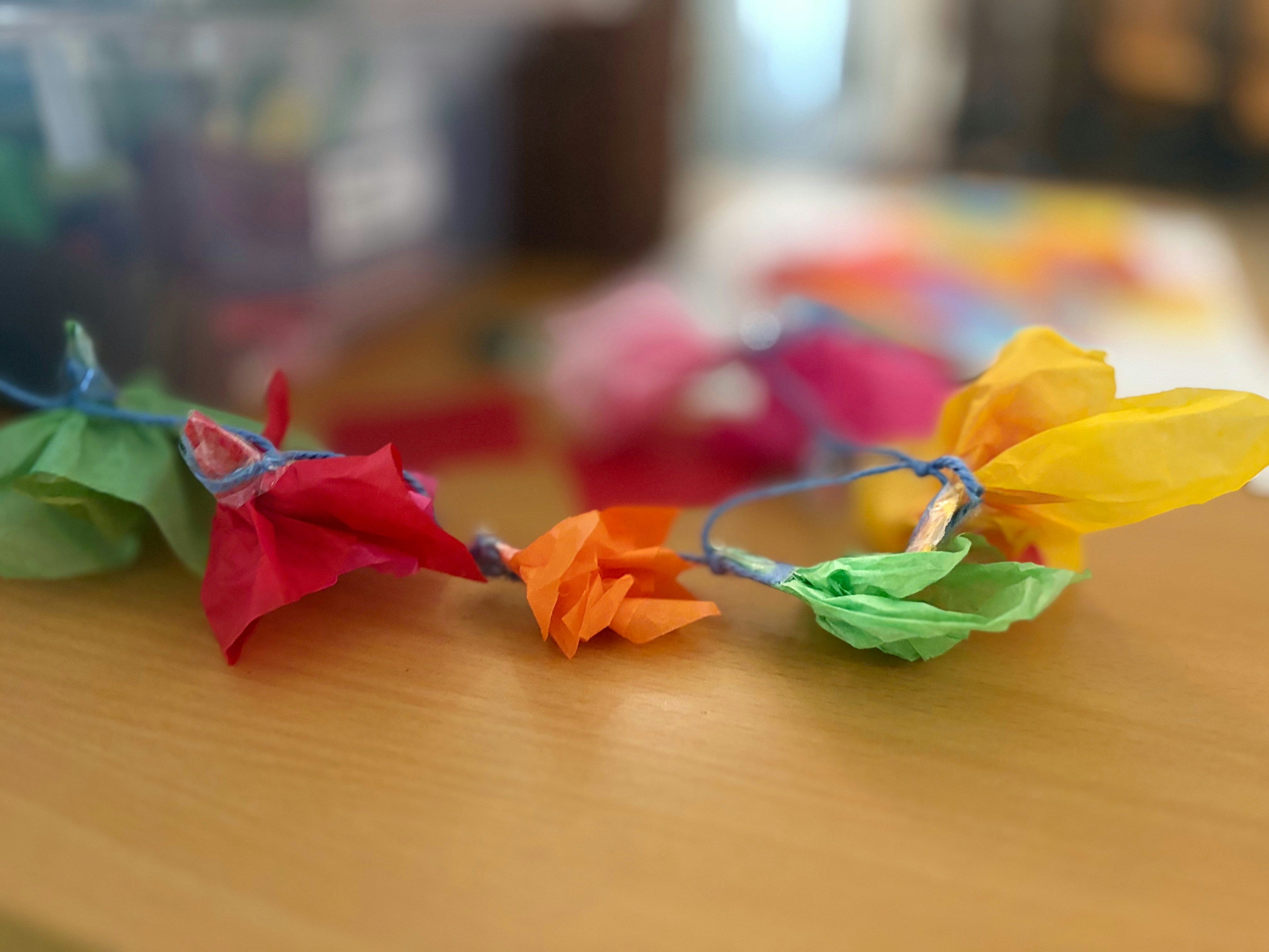 Crimson, Citrus, and Emerald: A Close-Up of a Paper Garland on Wood
