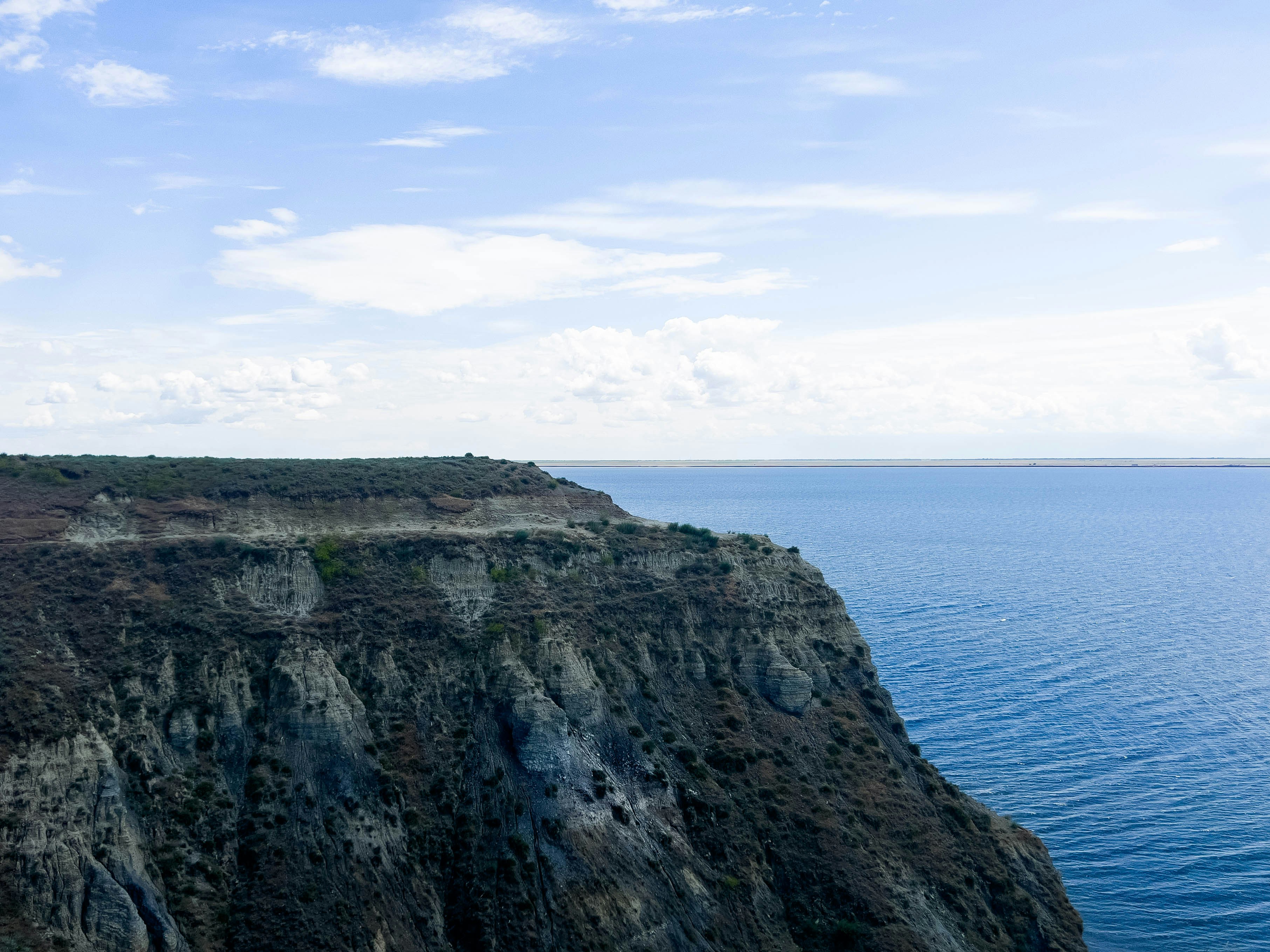 Cliffs border the ocean under a bright blue sky. photo – Free Beach ...