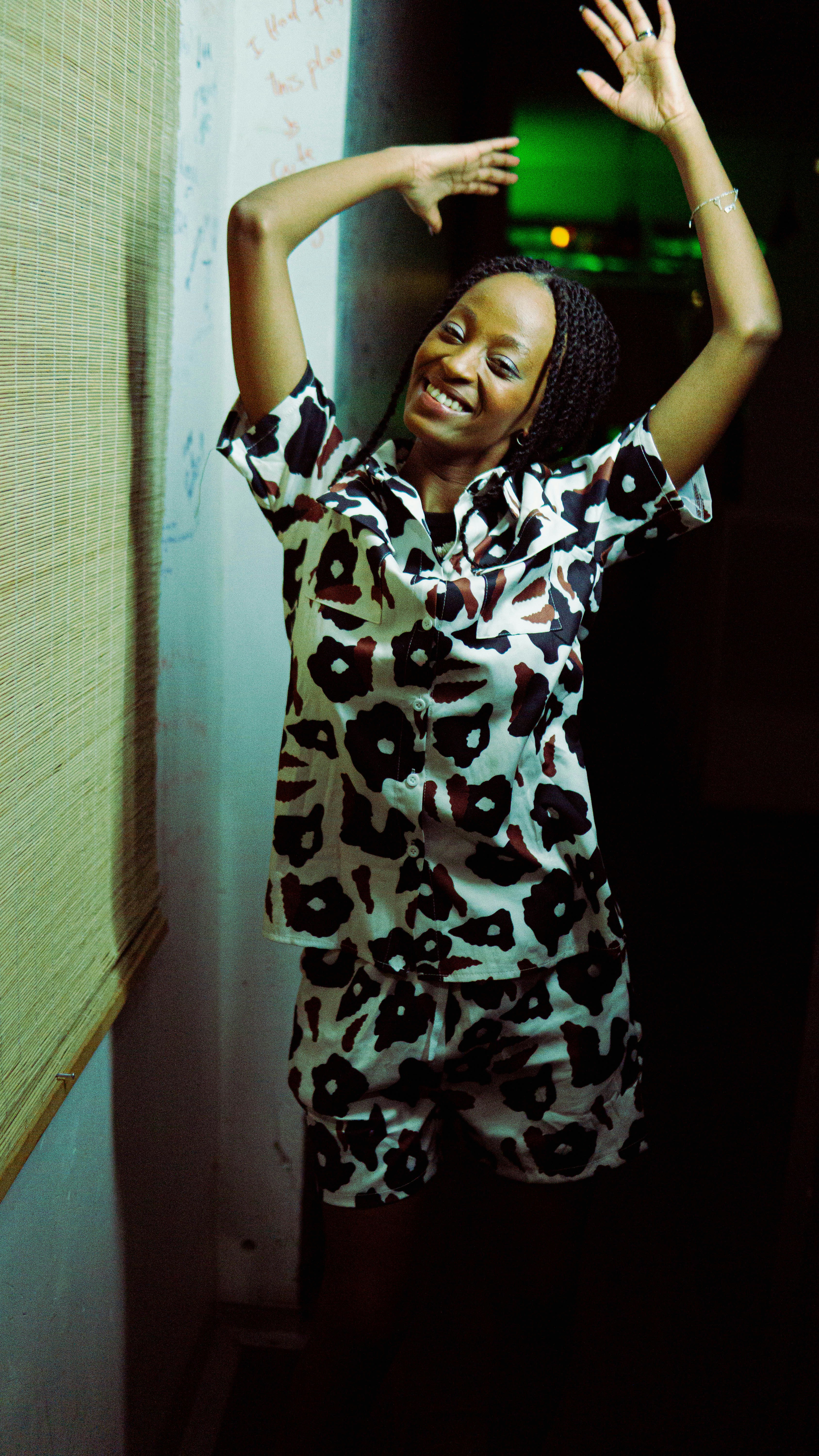 Woman in patterned outfit dances with arms raised. photo – Free ...