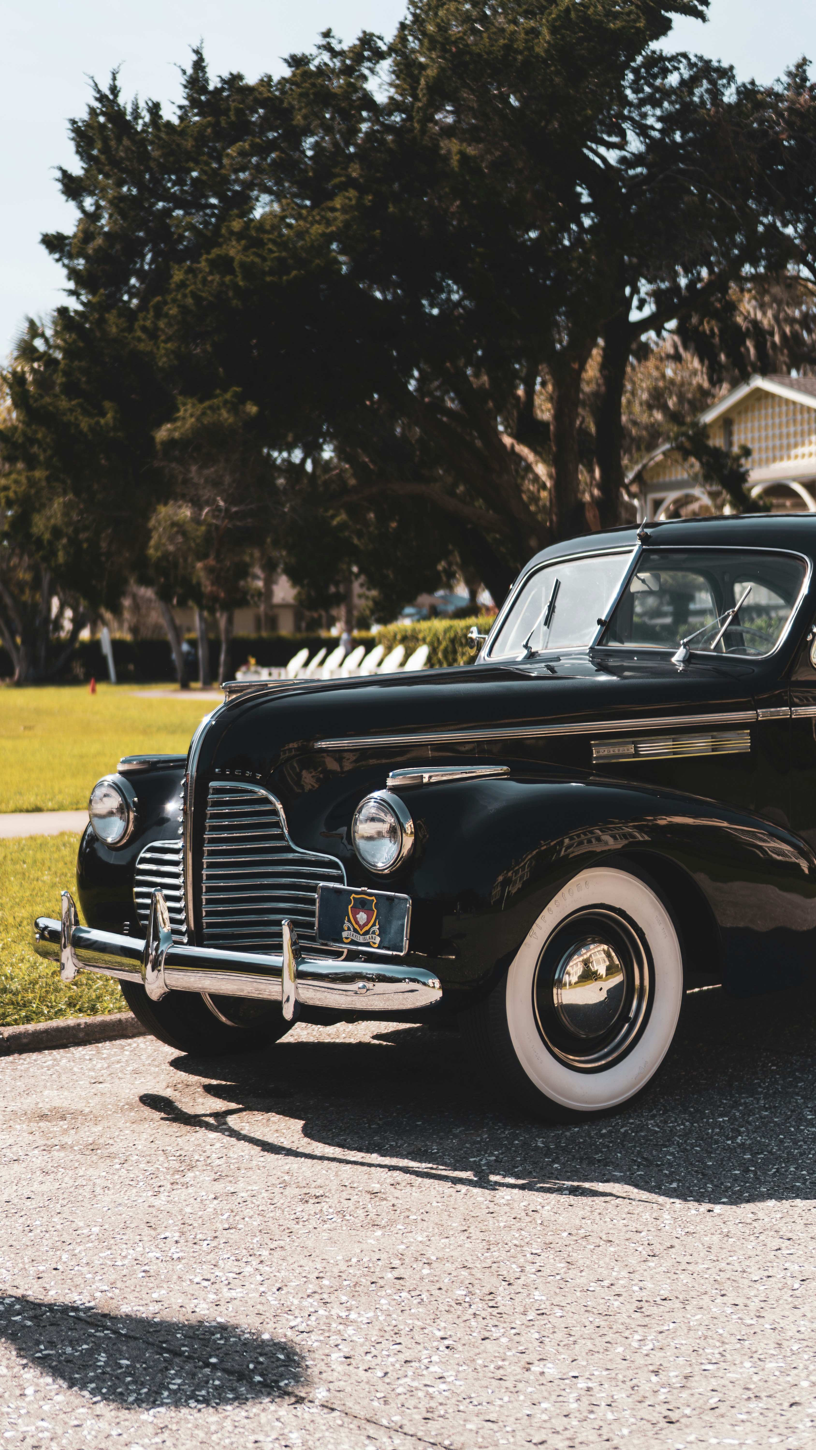 Sunlit Chrome: A 1940s Black Cruiser Gracing a Quiet Suburban Drive