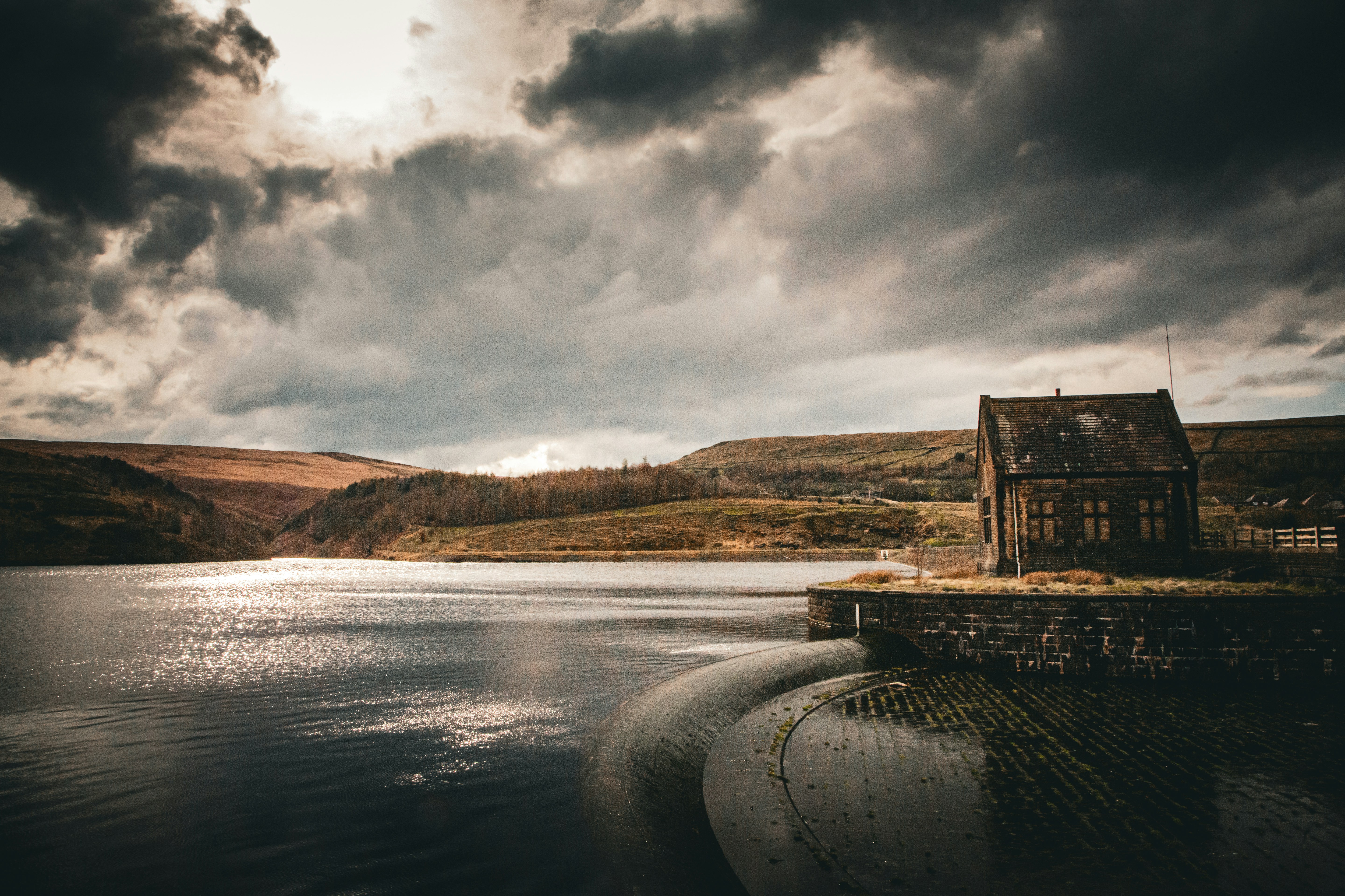 A building sits near water under a cloudy sky.