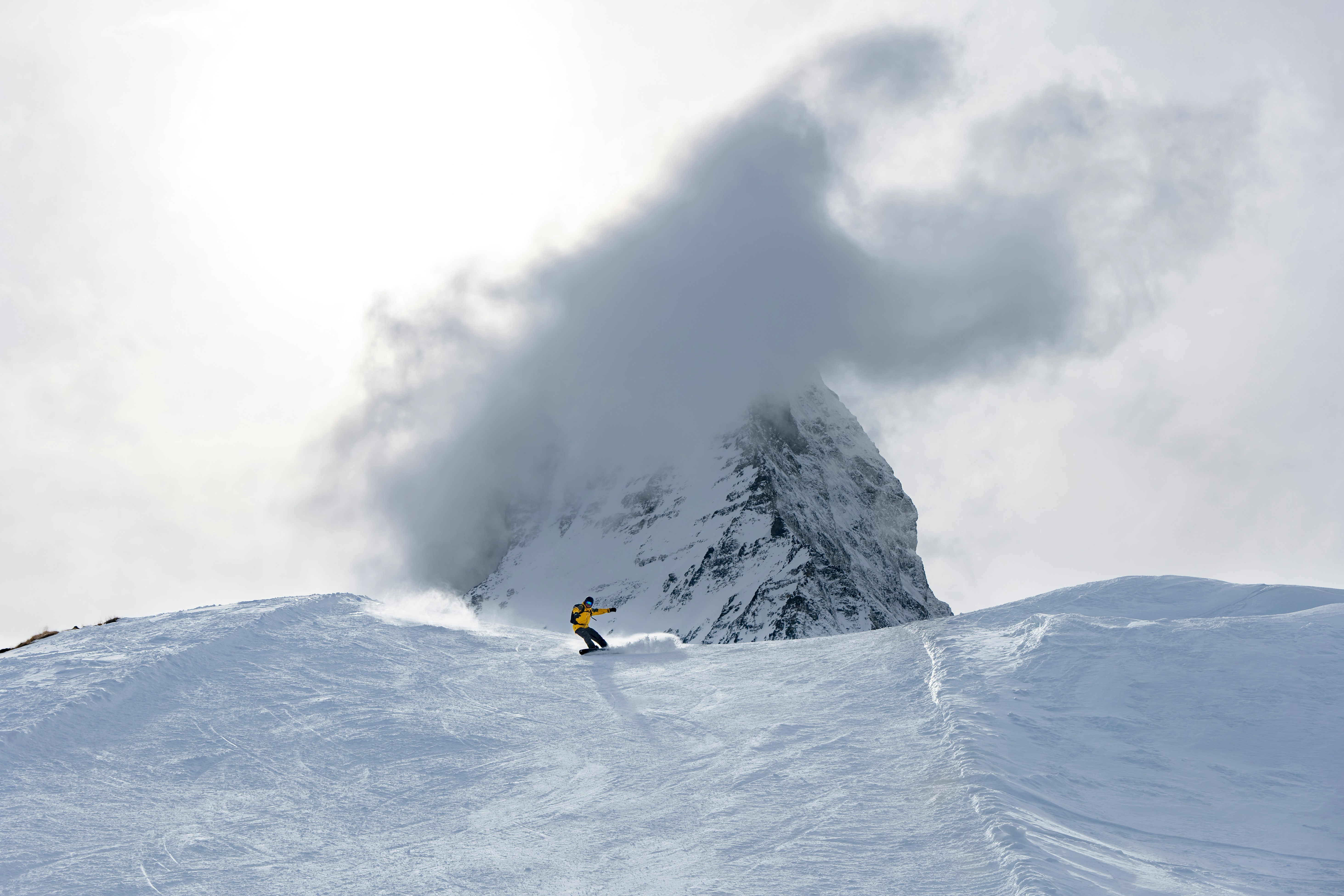 A snowboarder shreds down a snowy mountain.