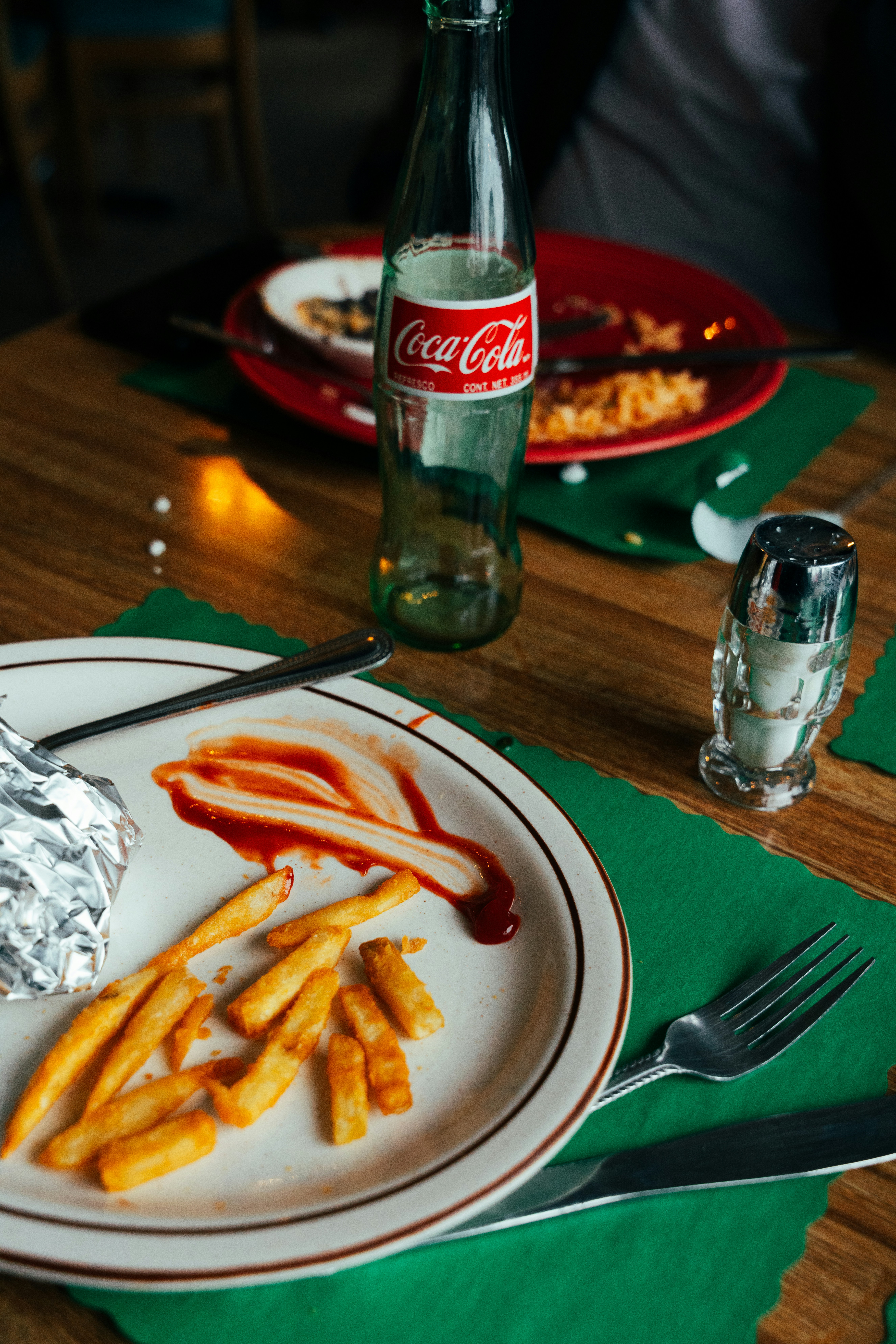 Finished meal with fries and a coke bottle.
