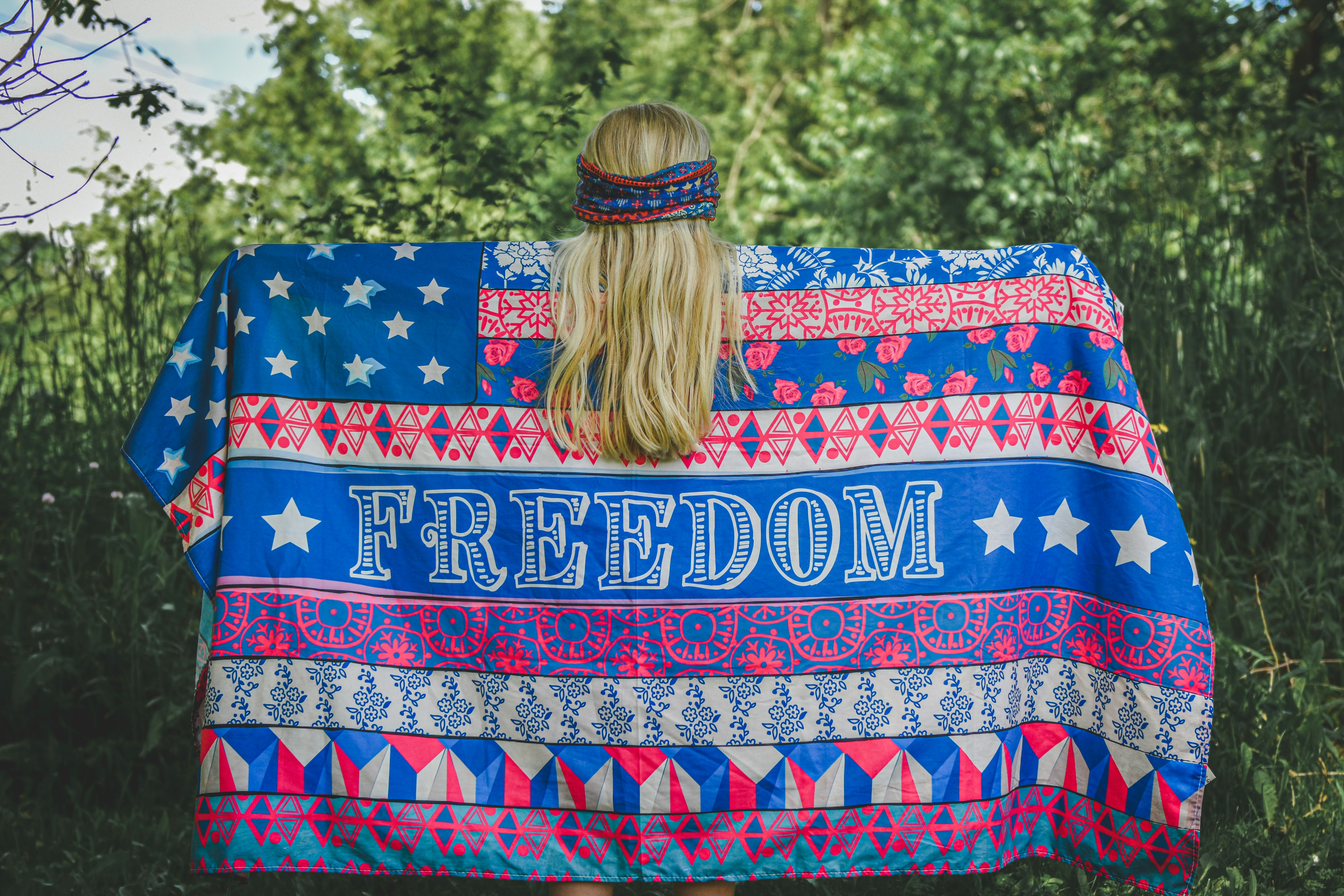 A woman holds a blanket saying freedom. photo – Free Woman Image on ...