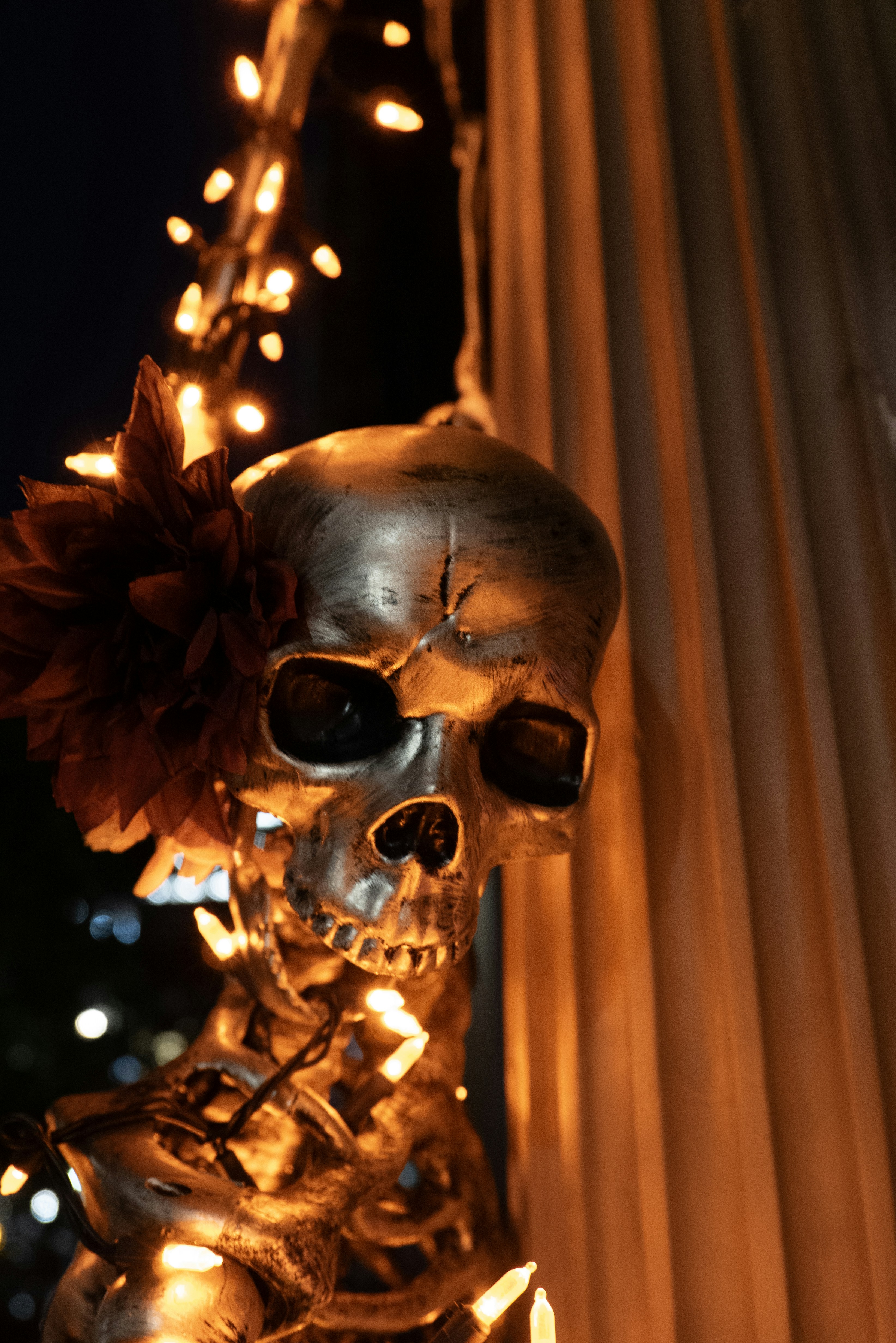 A metallic skull decorates with lights and a flower.