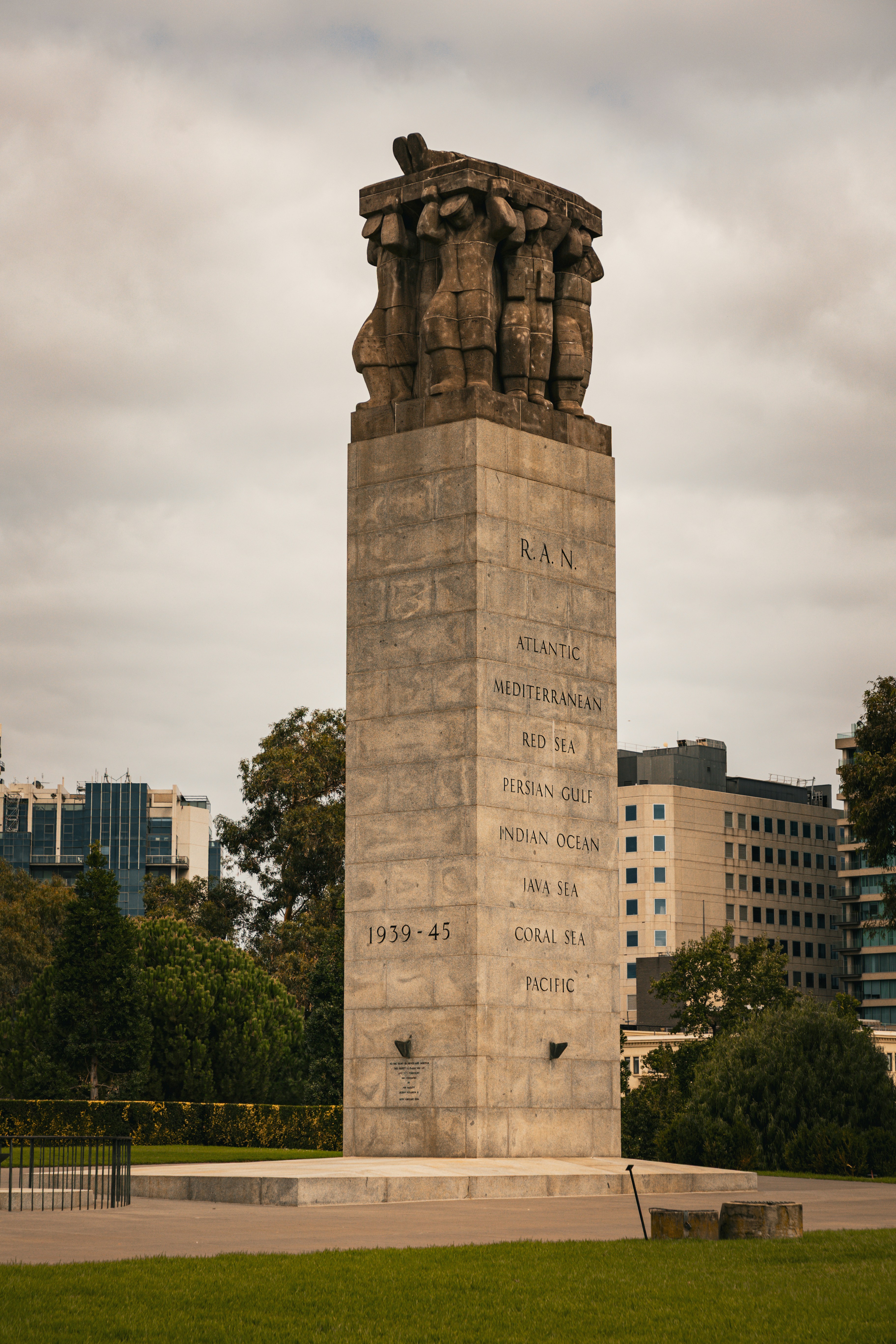 A war memorial stands tall on a grassy park. photo – Free Man Image on ...
