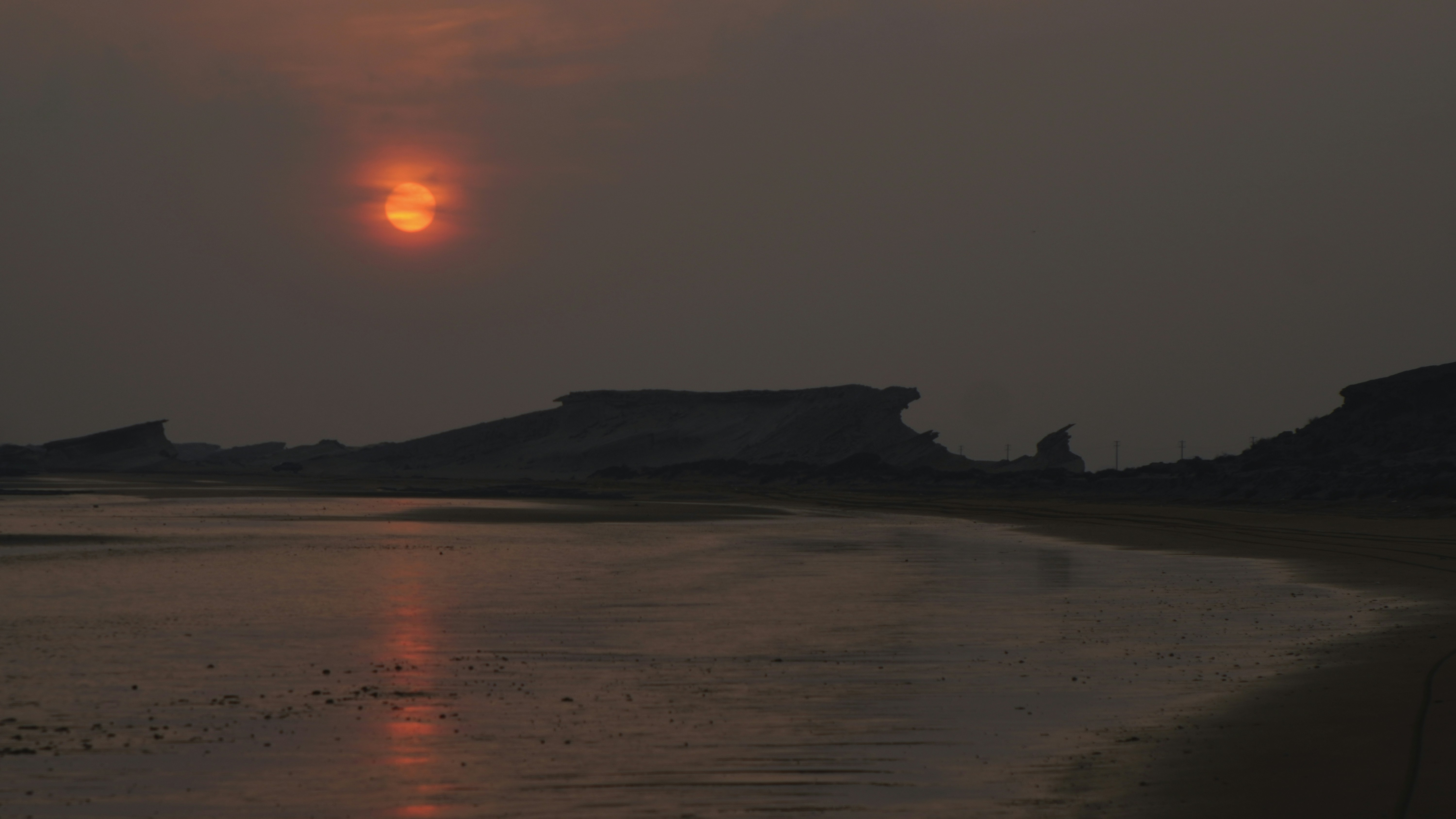 Sunset Silhouettes Over Coastal Reflections