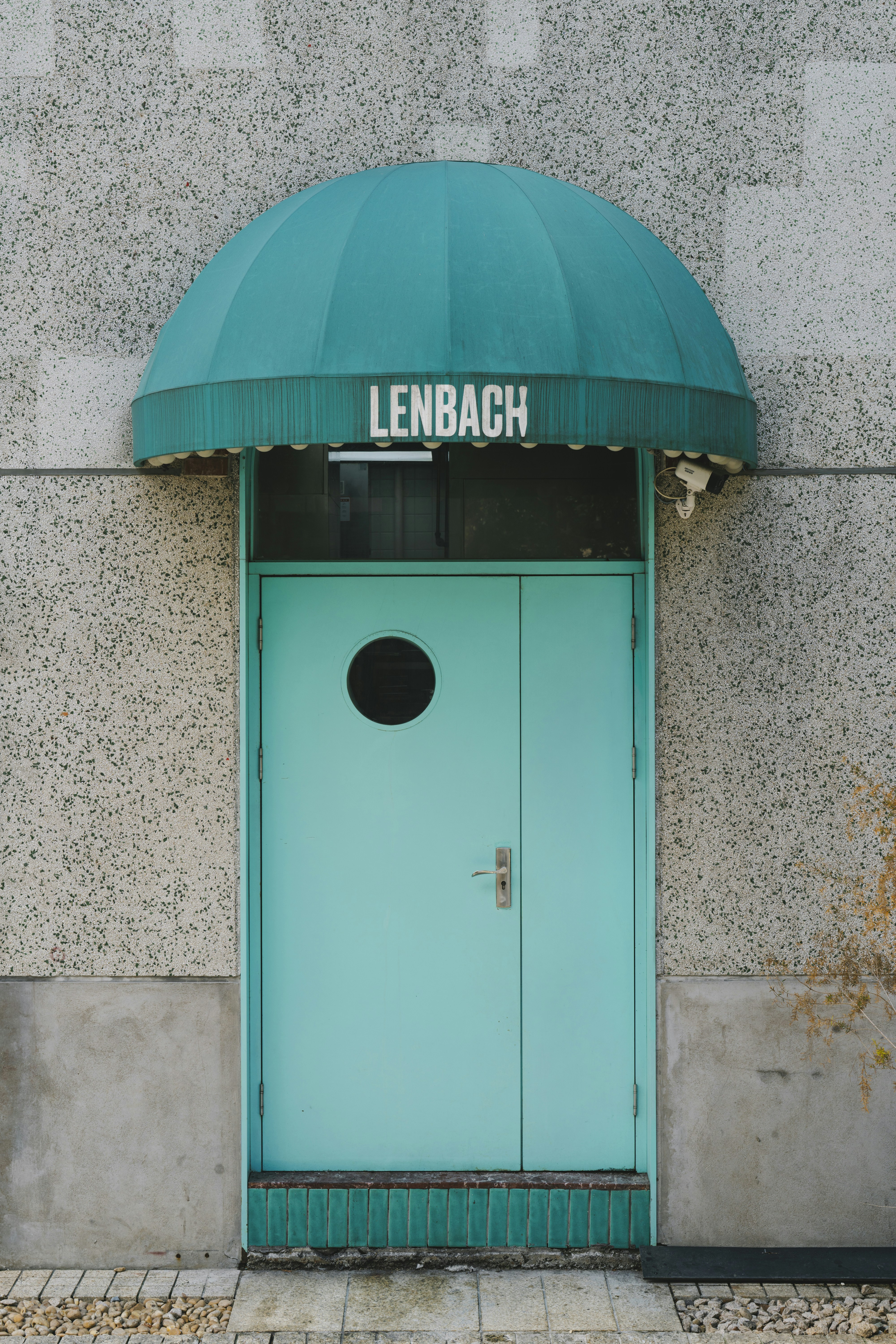 Turquoise Portal on Textured Facade