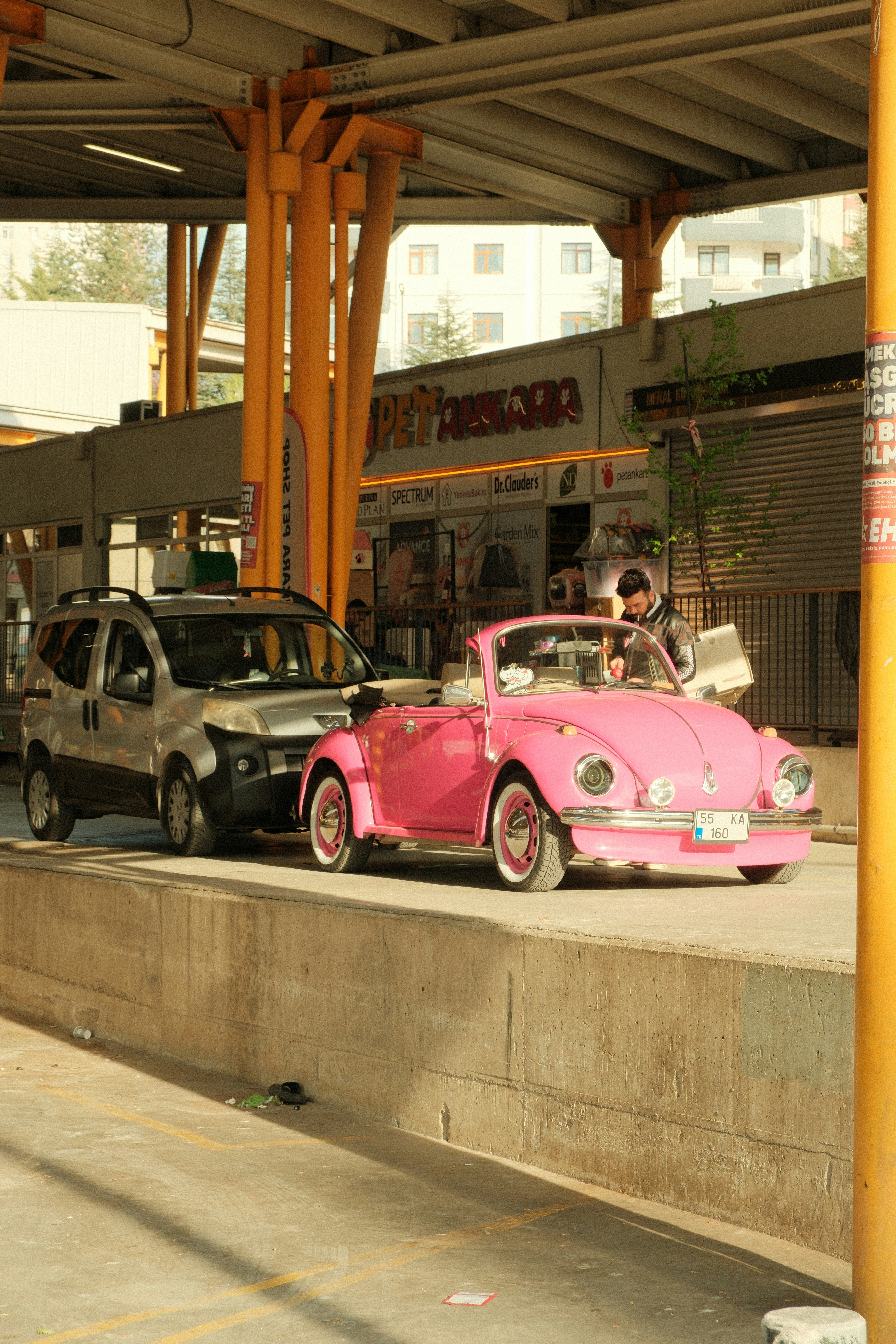 Sunlit Pink Beetle at the Station: a Retro Pop Under Yellow Canopies