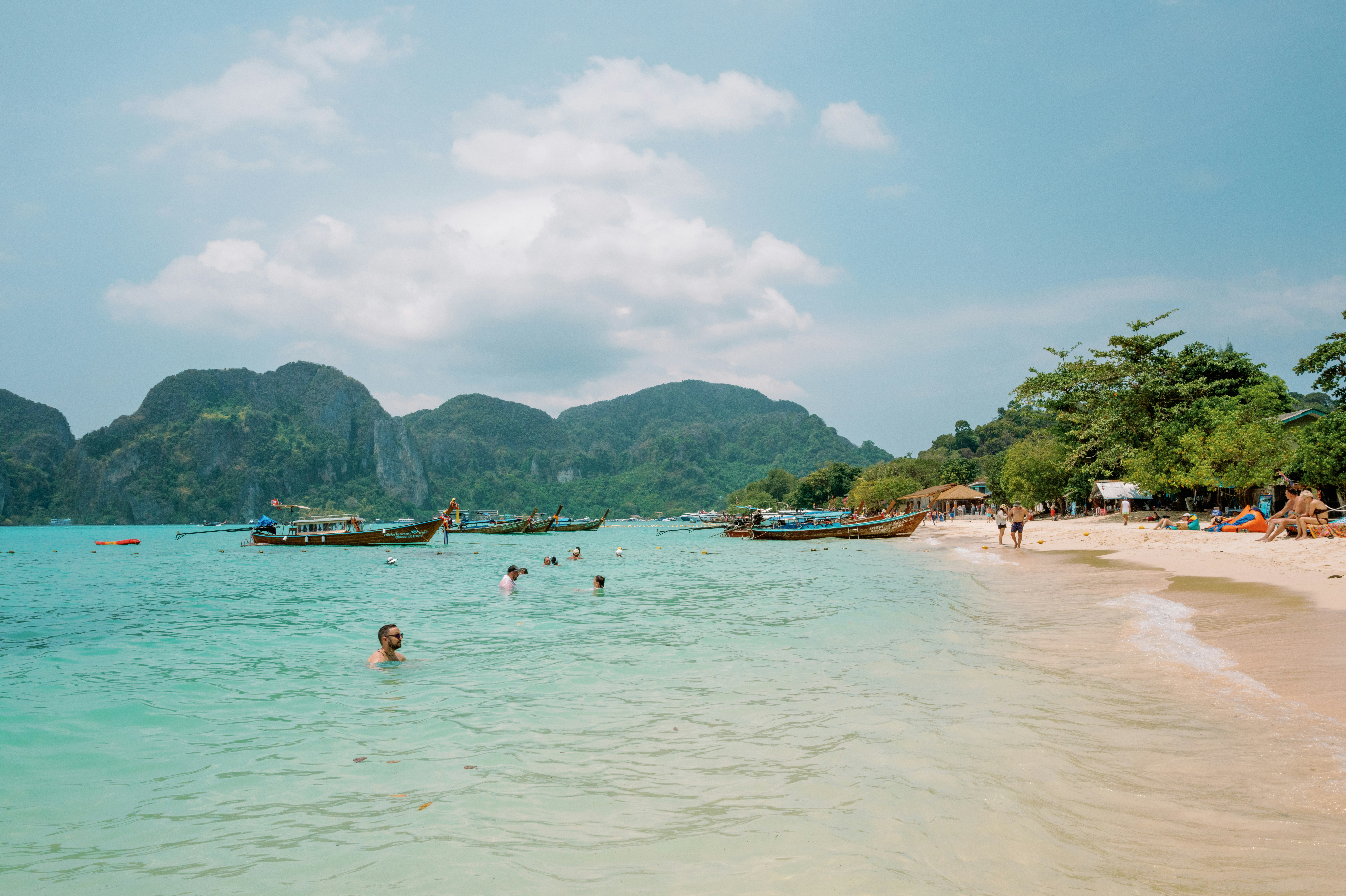 Beachgoers enjoy a beautiful tropical paradise with boats. photo – Free ...