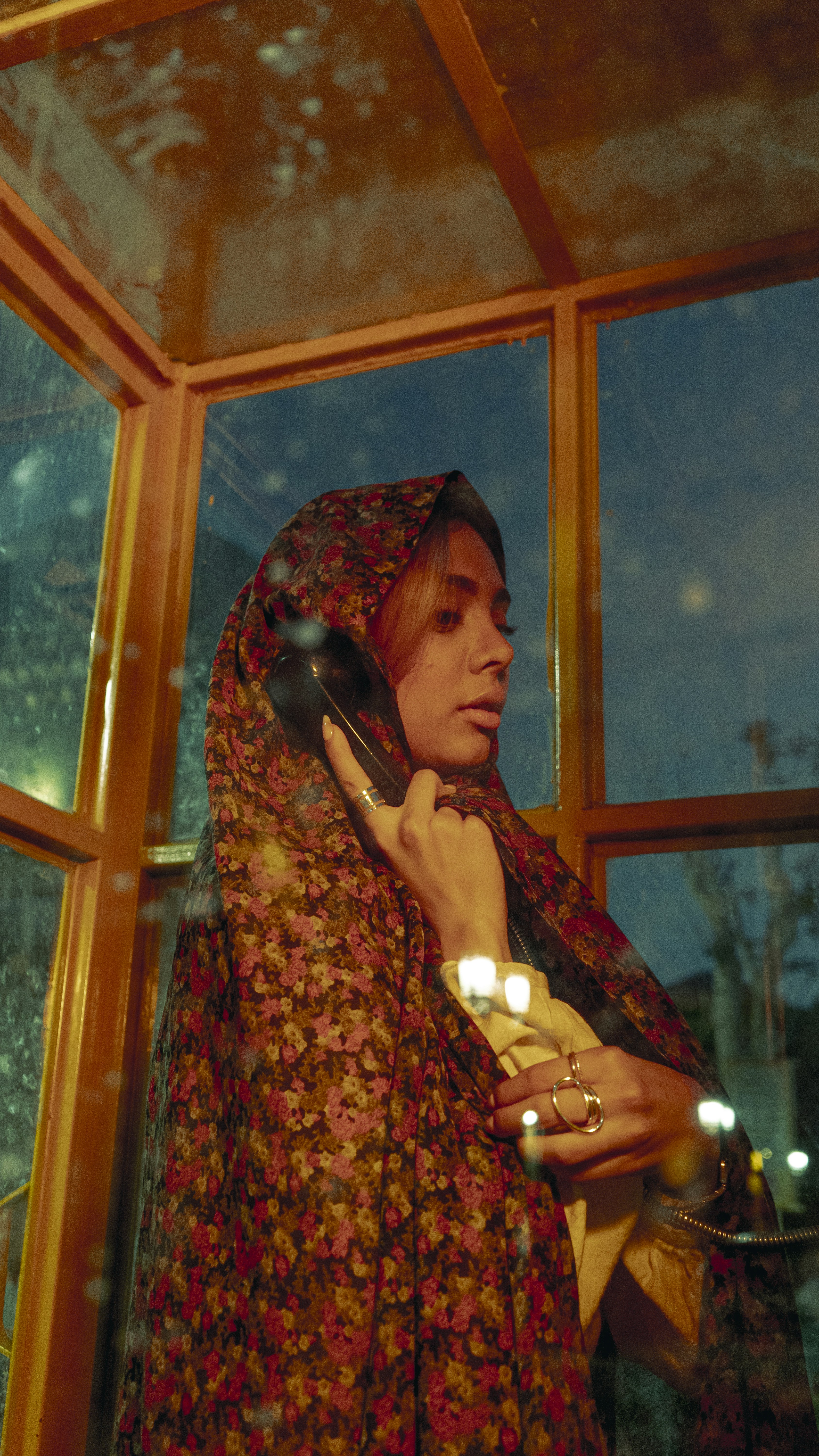 Amber Glass, Floral Veil: A Night Portrait Inside a Glass-Walled Shelter