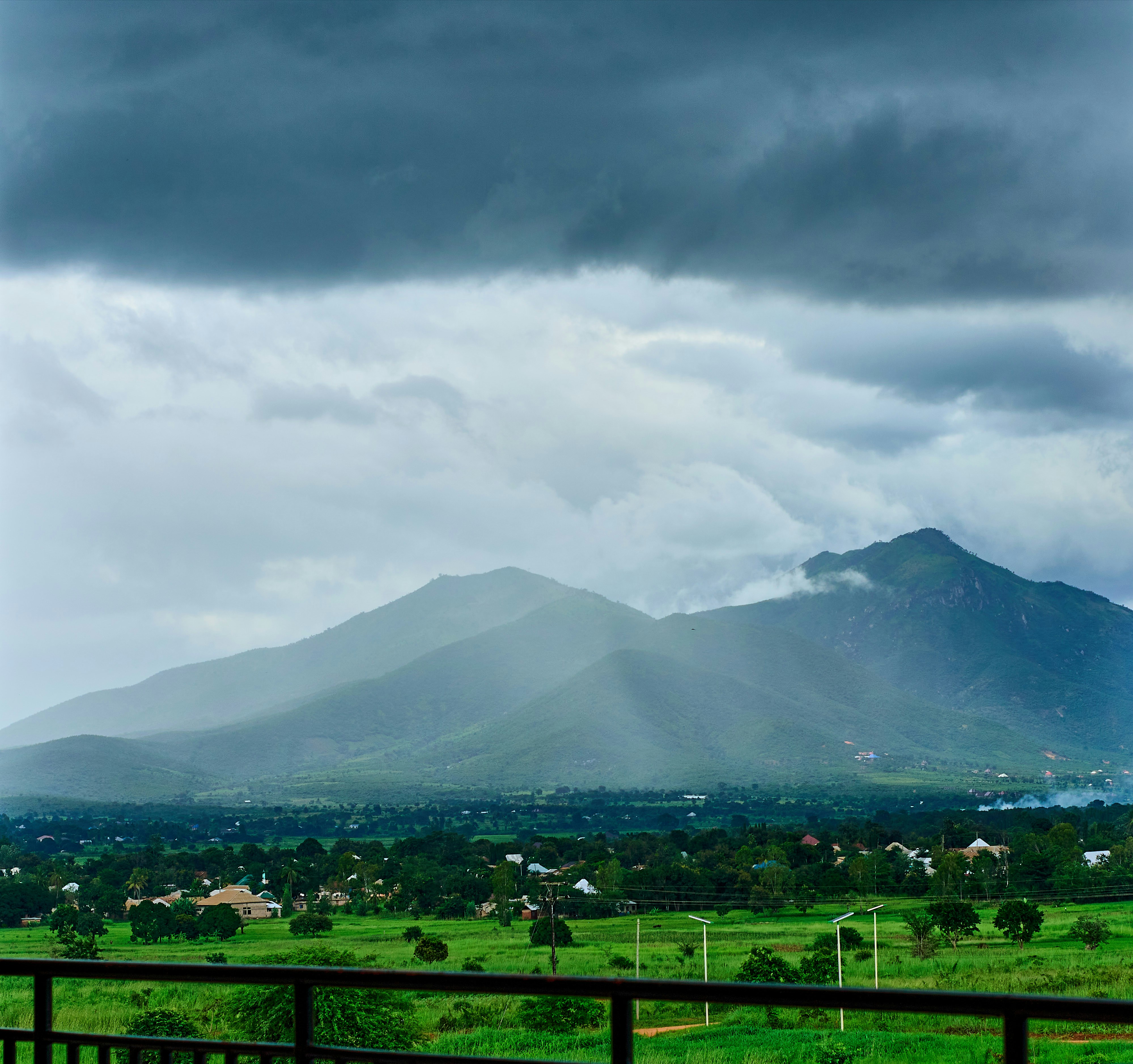Storm-Trimmed Ridge Over a Verdant Valley with Distant Turbines