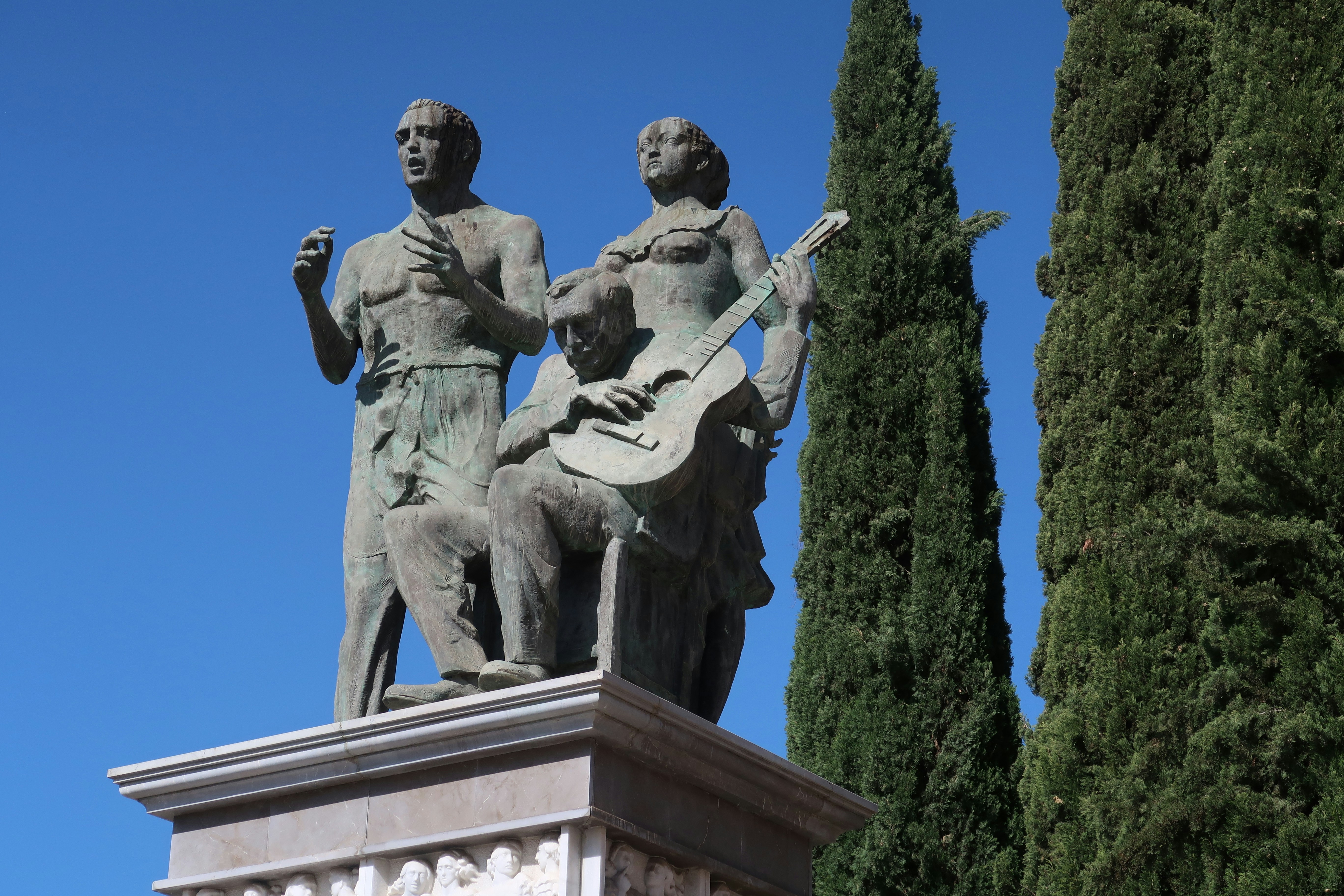 Stone Duet: Two Musicians Carved in Marble Above the Plaza