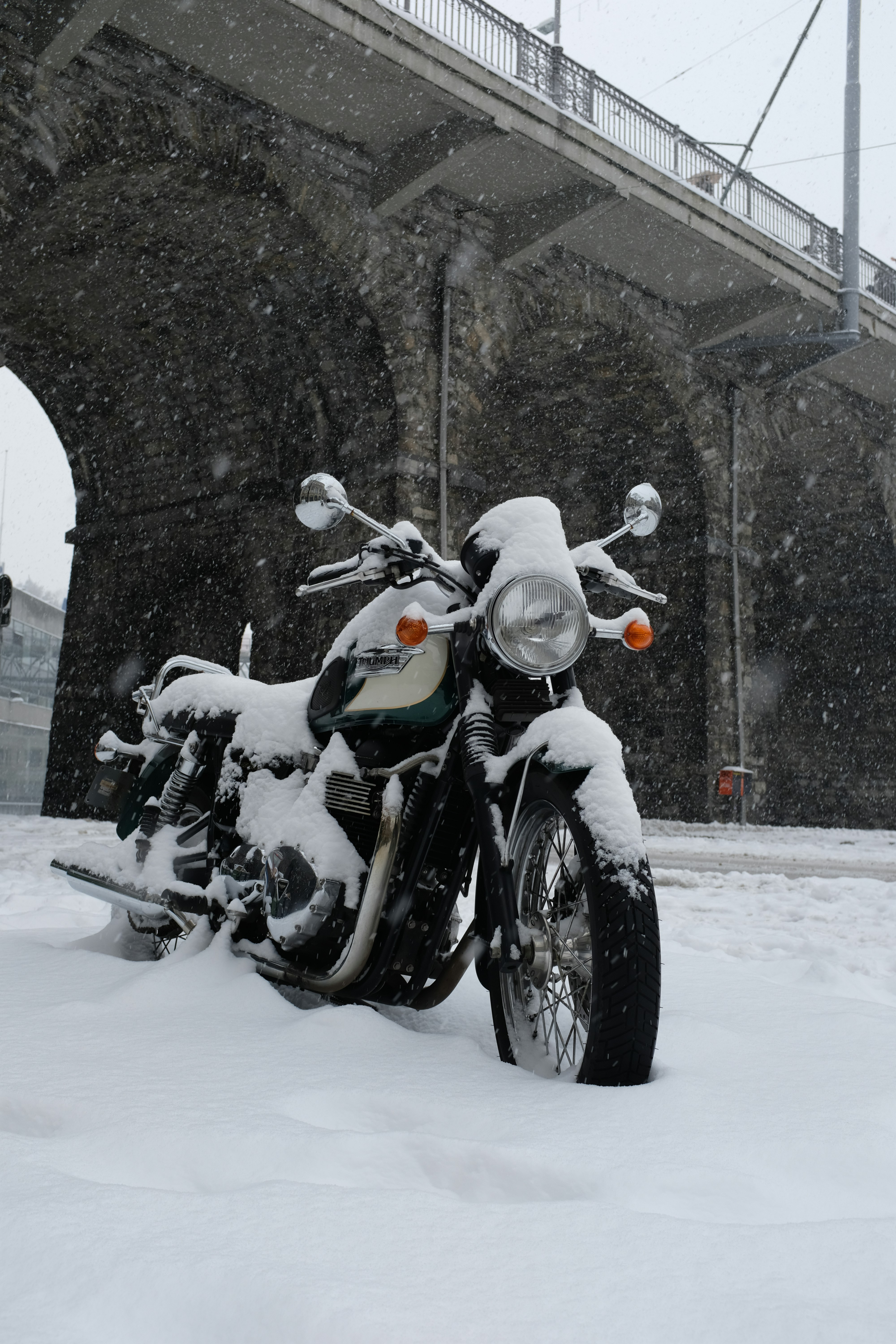 A snow-covered motorcycle parks under a bridge. photo – Free Winter ...