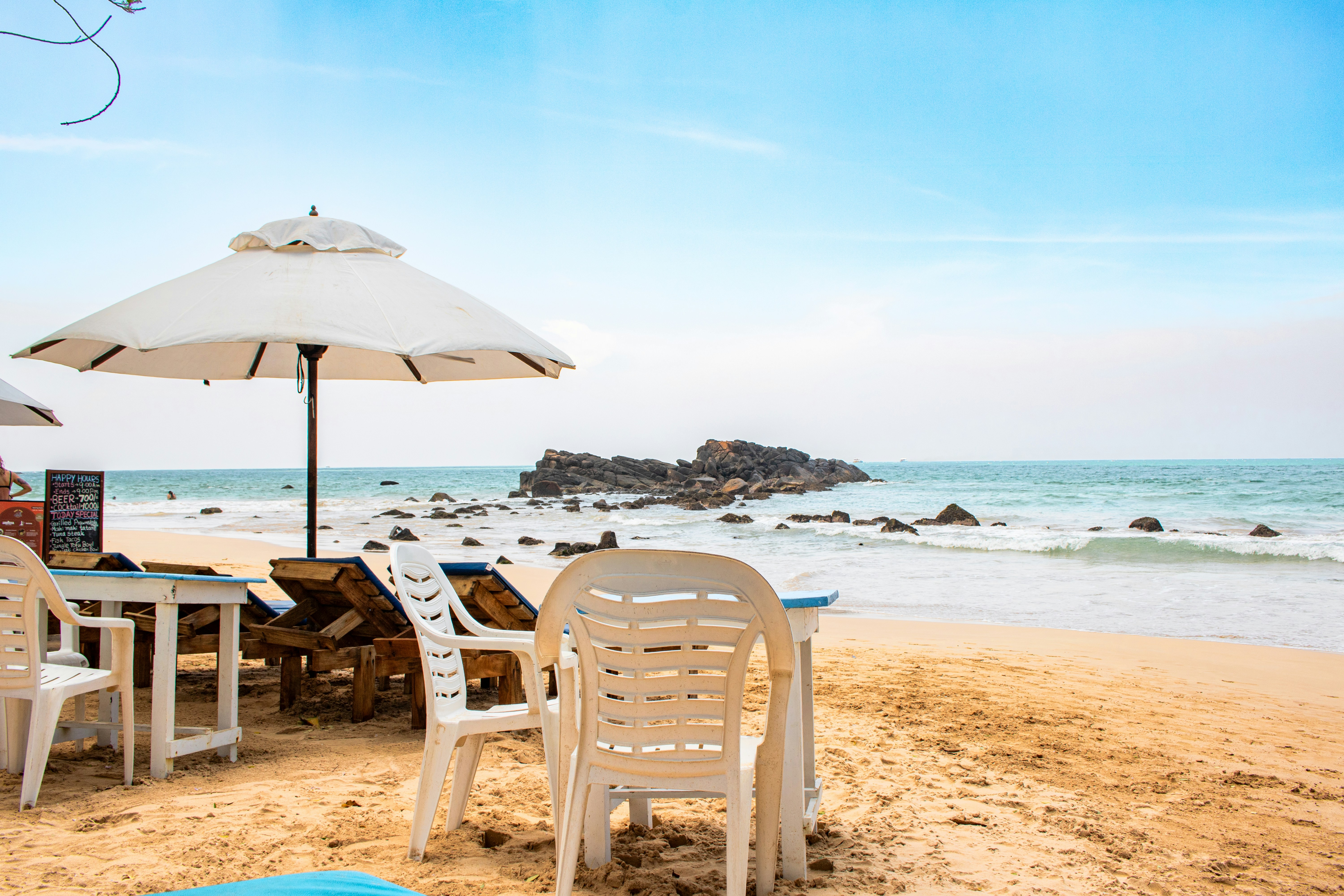Beach scene with umbrellas, tables, and ocean view. photo – Free Beach ...