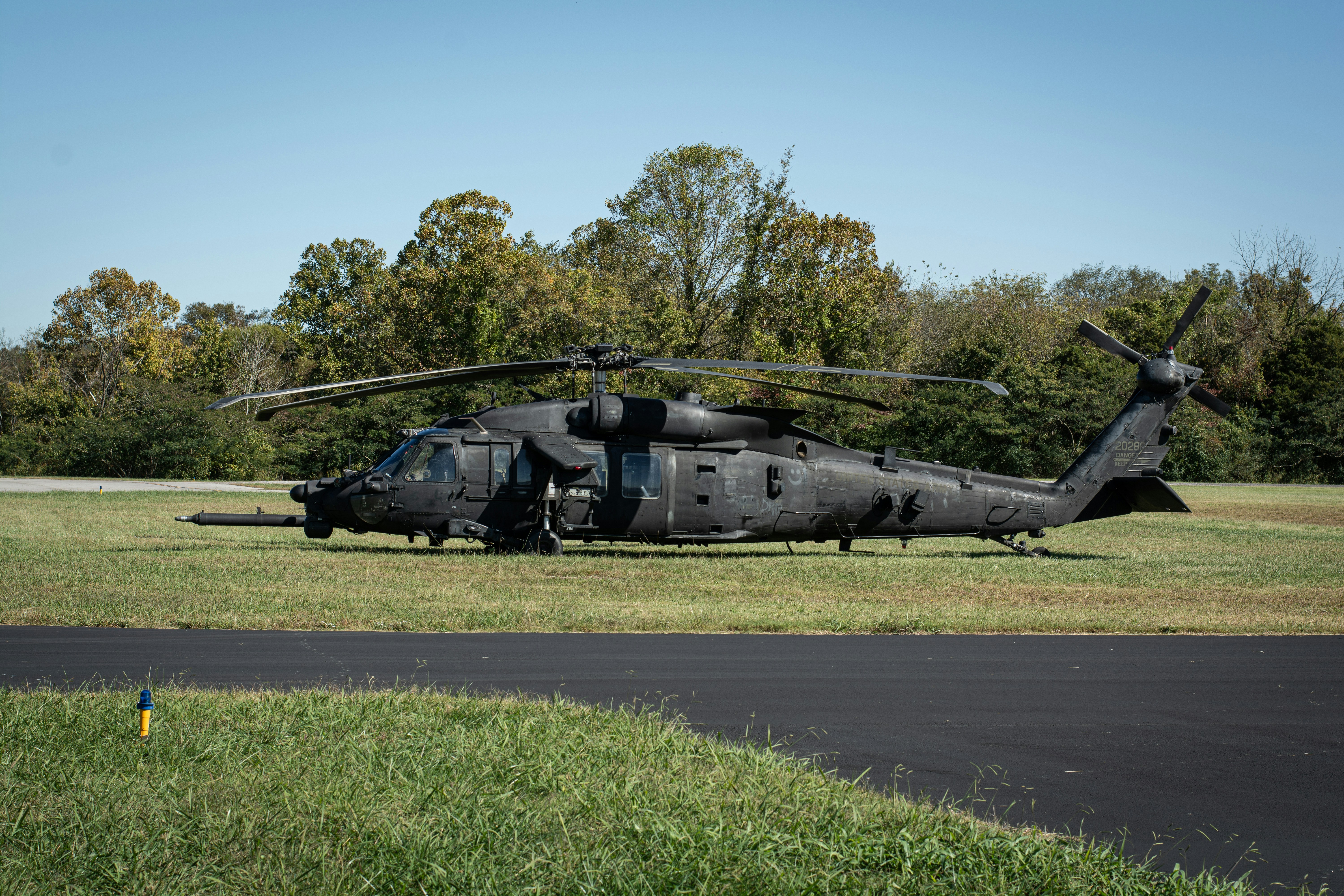A blackhawk helicopter sits on a grassy field. photo – Free Human Image ...