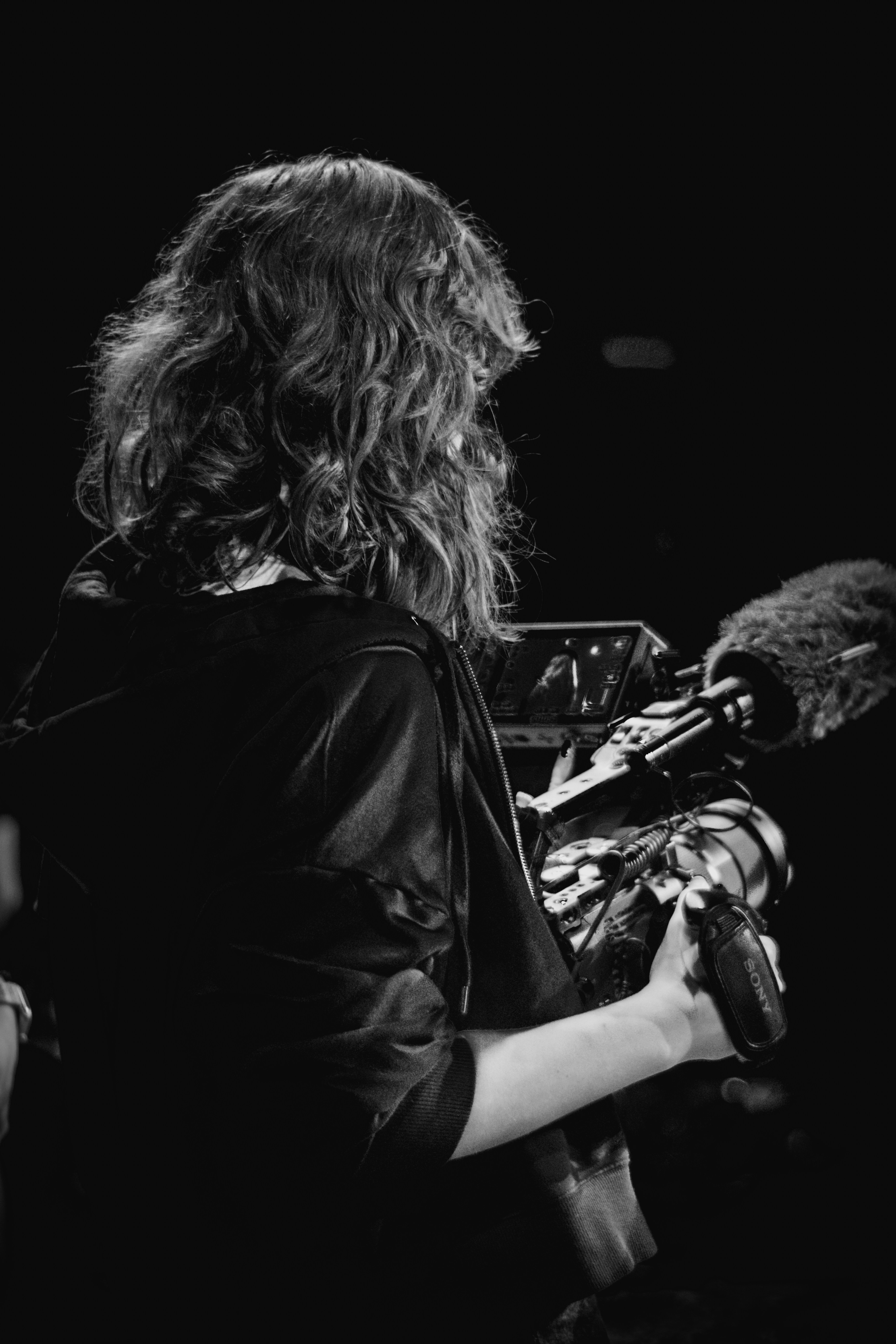 Backstage Focus: A Dim-Stage Cameraman Framed by a Handheld Rig