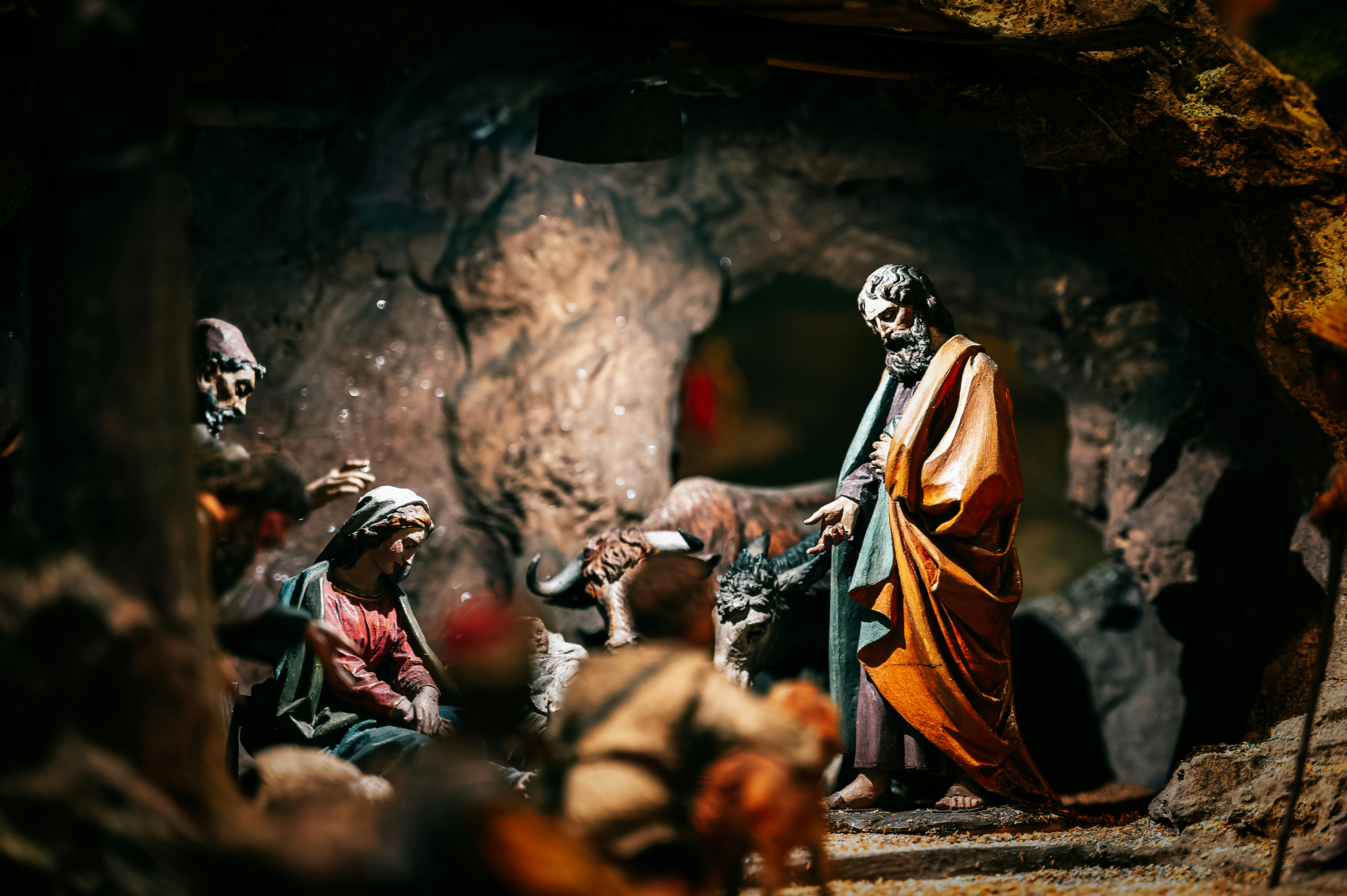 People listen to a figure in a cave.