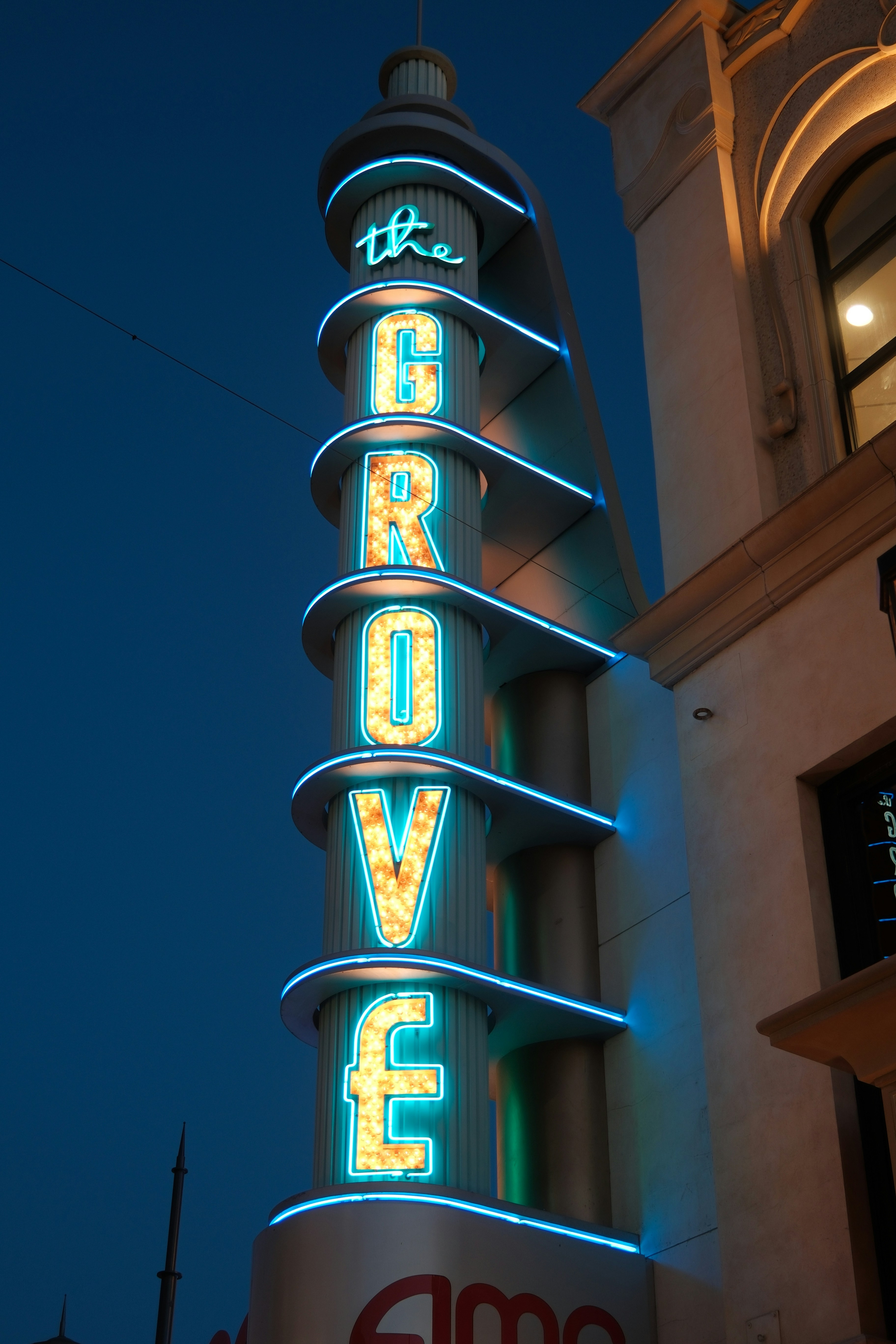The grove sign is lit up against a night sky. photo – Free City Image ...