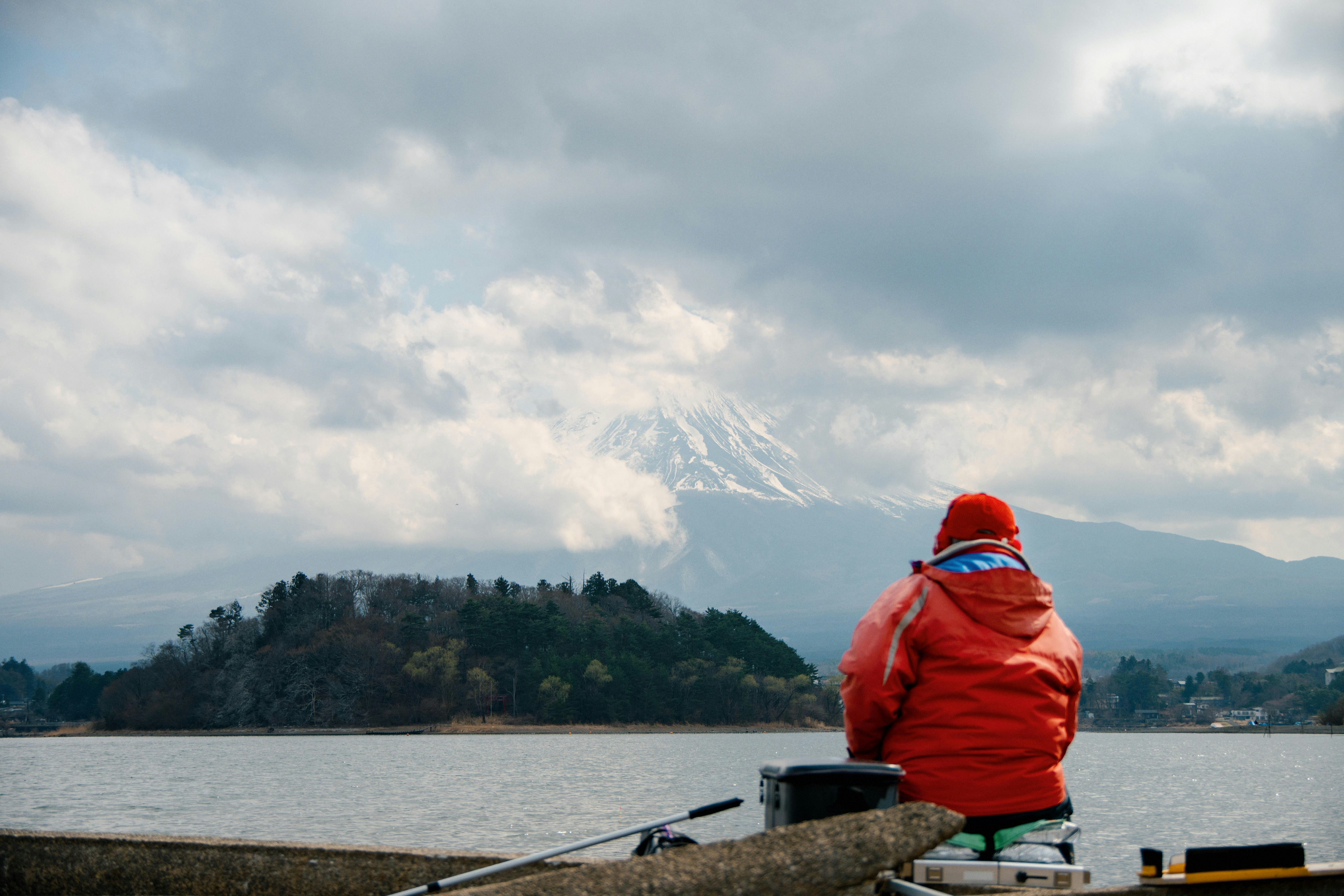 Red Jacket at the Distant Edge: Quiet Lake and Snow-Capped Peak
