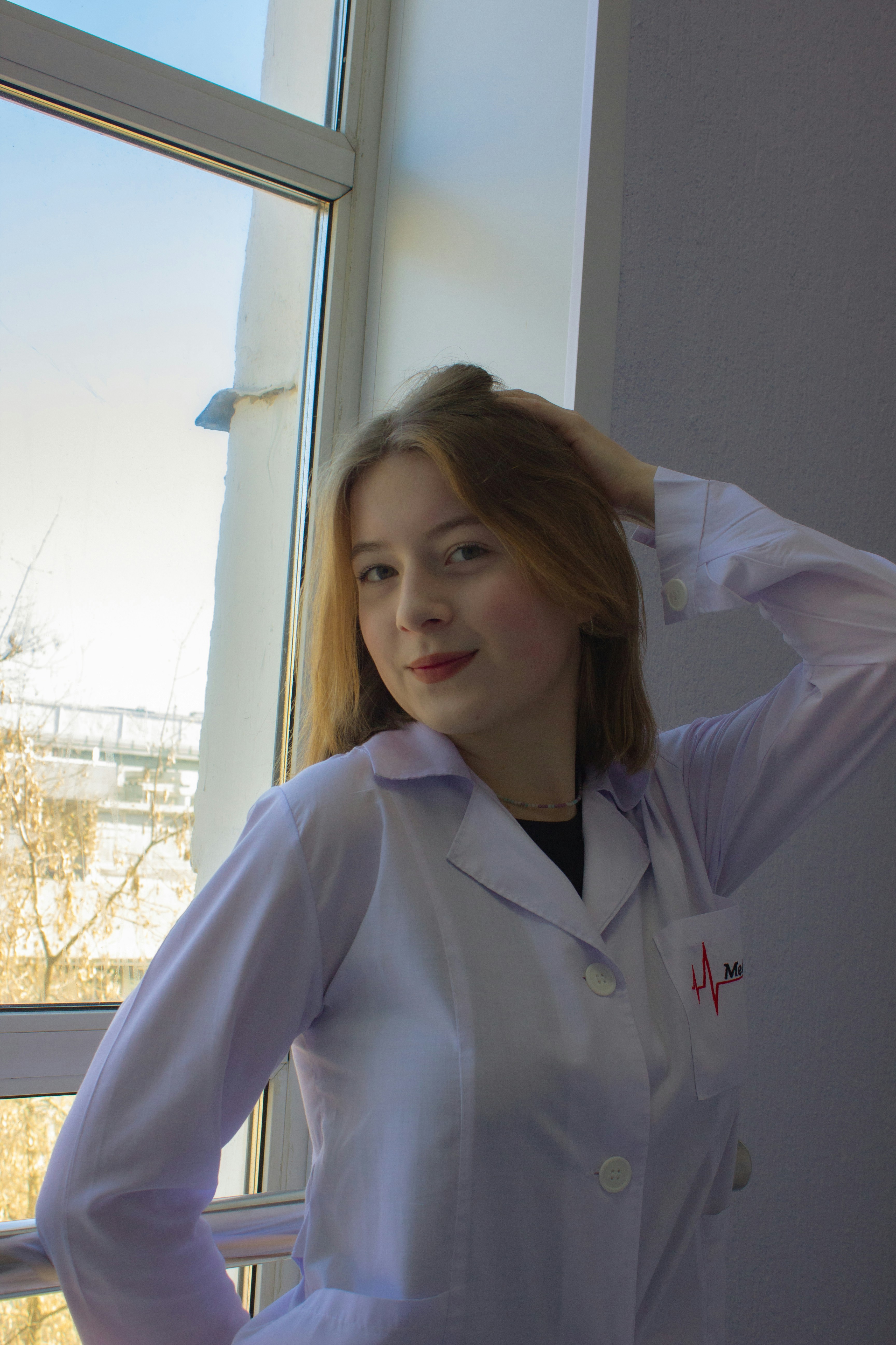 A young woman poses in a white lab coat. photo – Free Portrait Image on ...