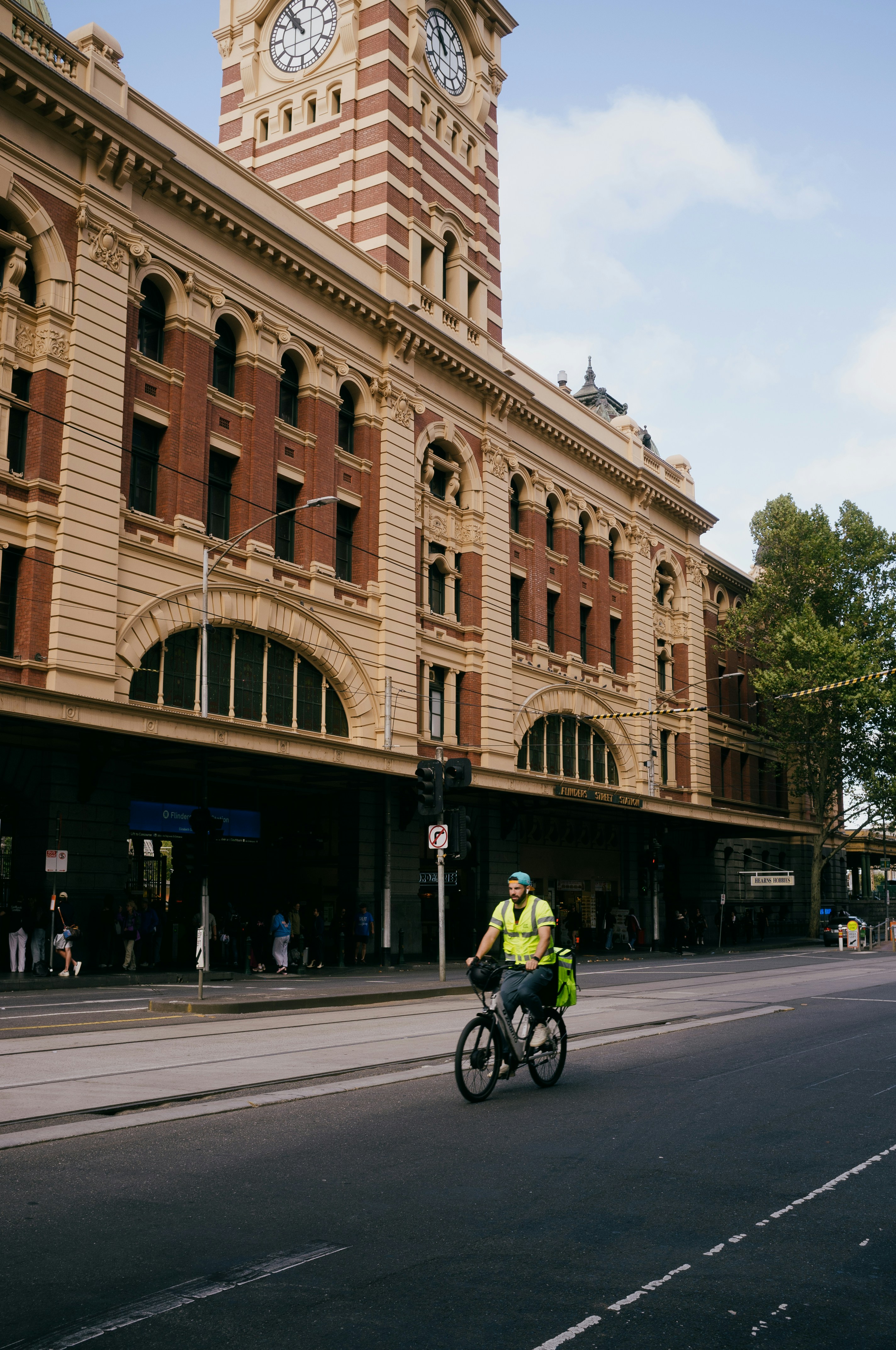 Rider in Neon Vest Traverses an Historic Brick Facade