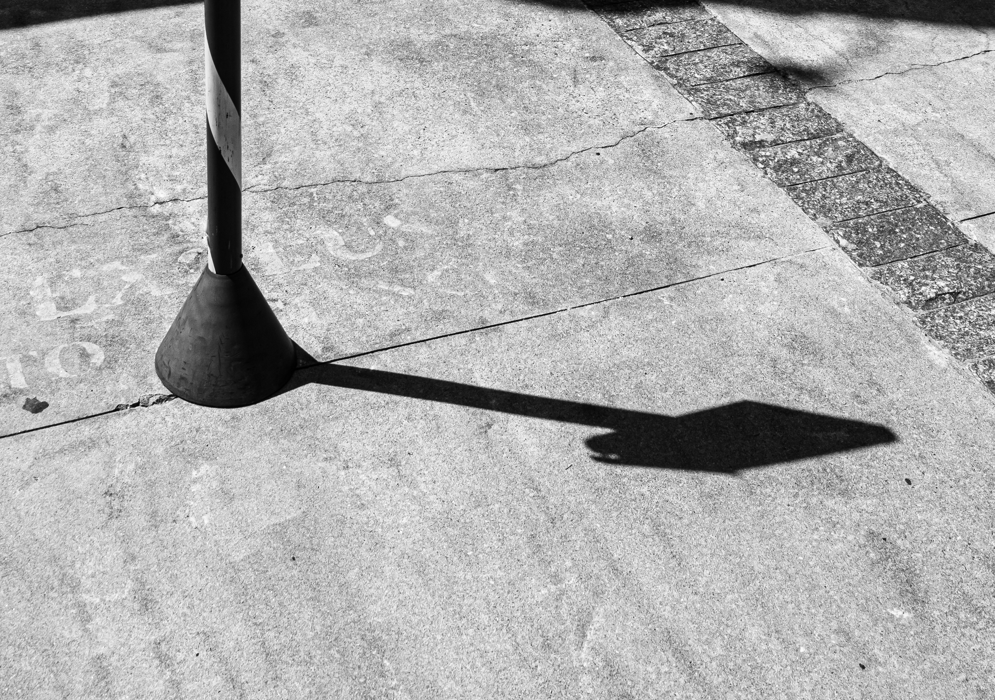 A shadow points the way on the pavement. photo – Free Road Image on ...