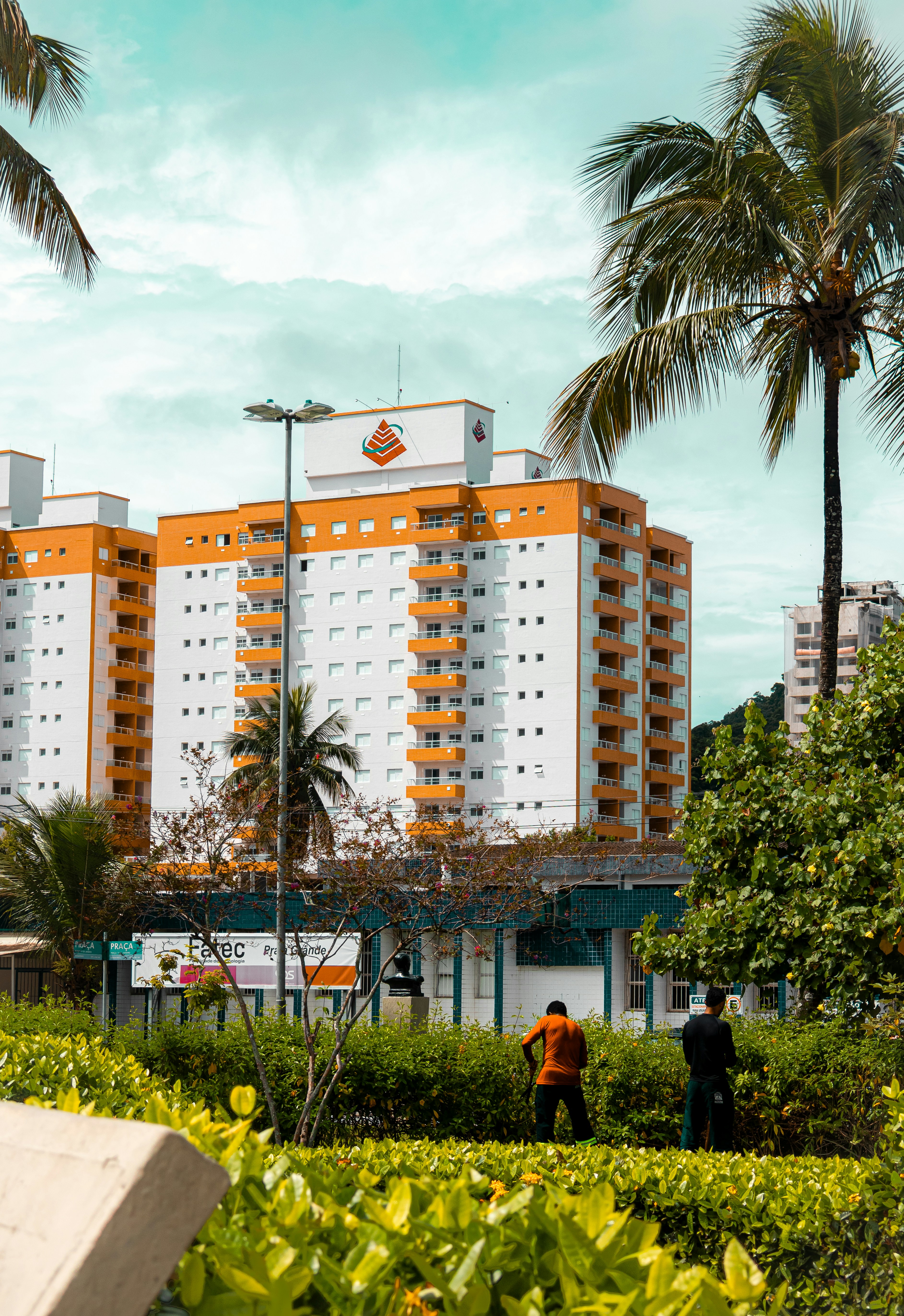 Sunlit Orange-White High-Rise Framed by Tropical Palms