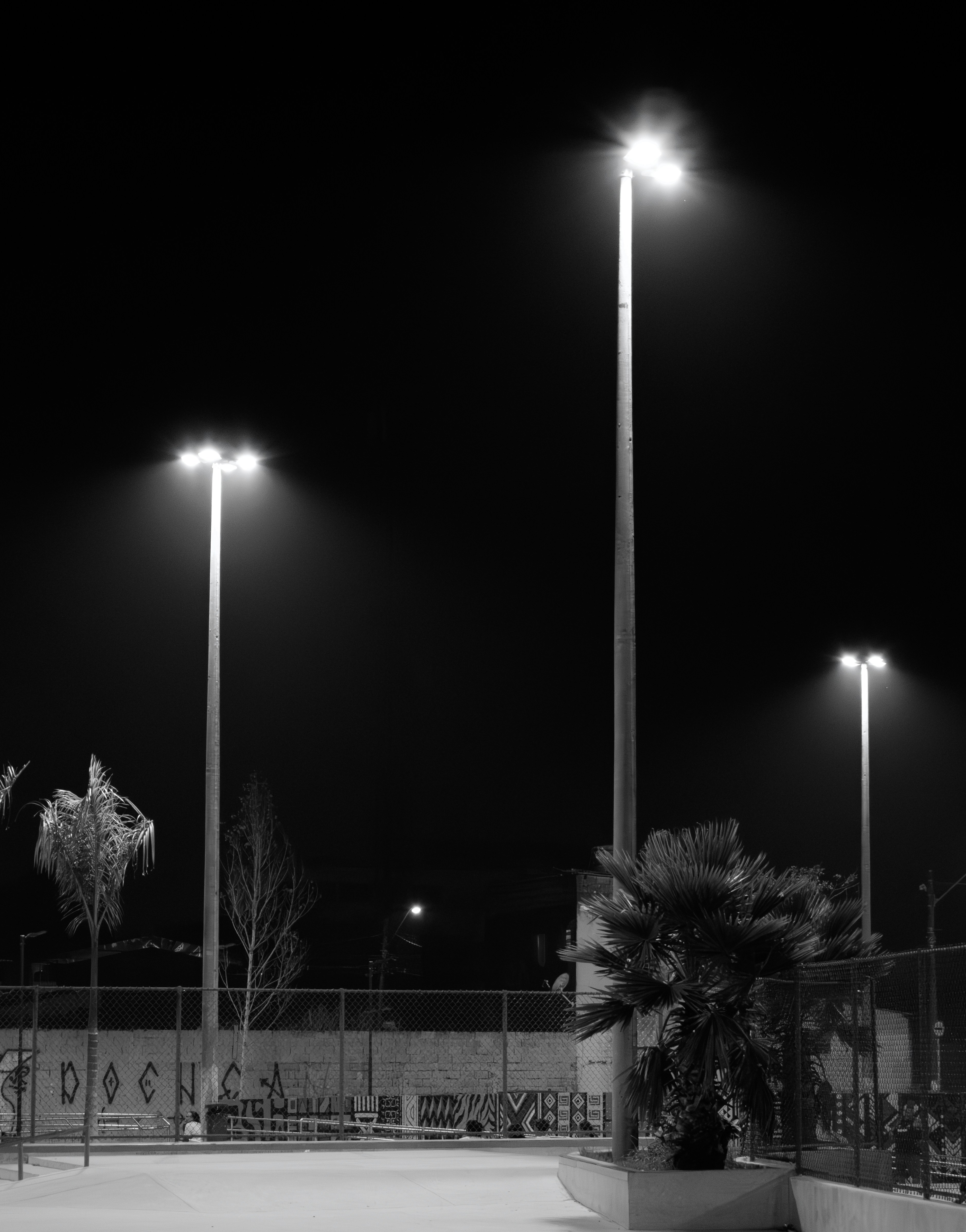 Skate Park foggy night | Street lights illuminate a dark outdoor area at night.