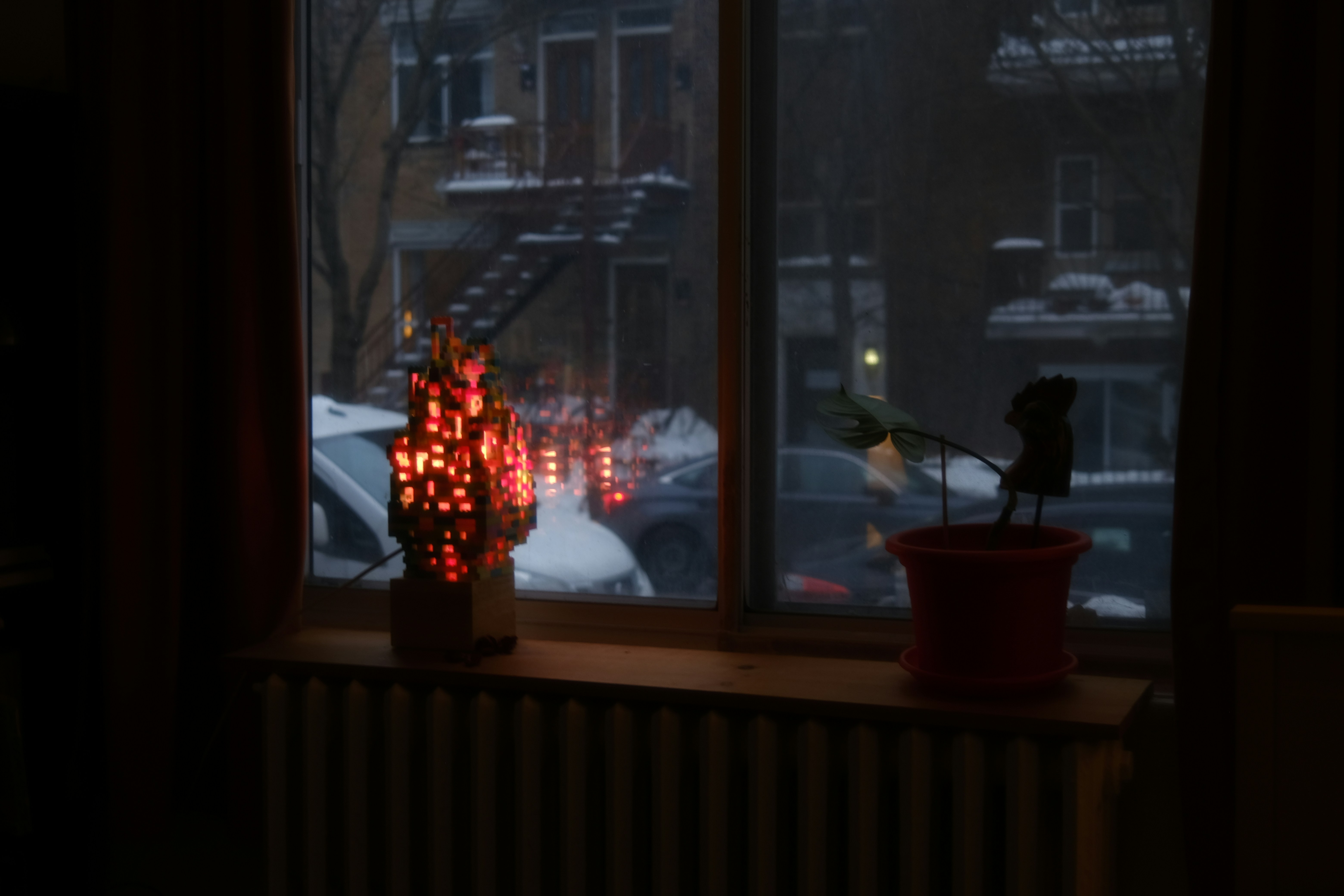 Warm lights shine through a snowy window.