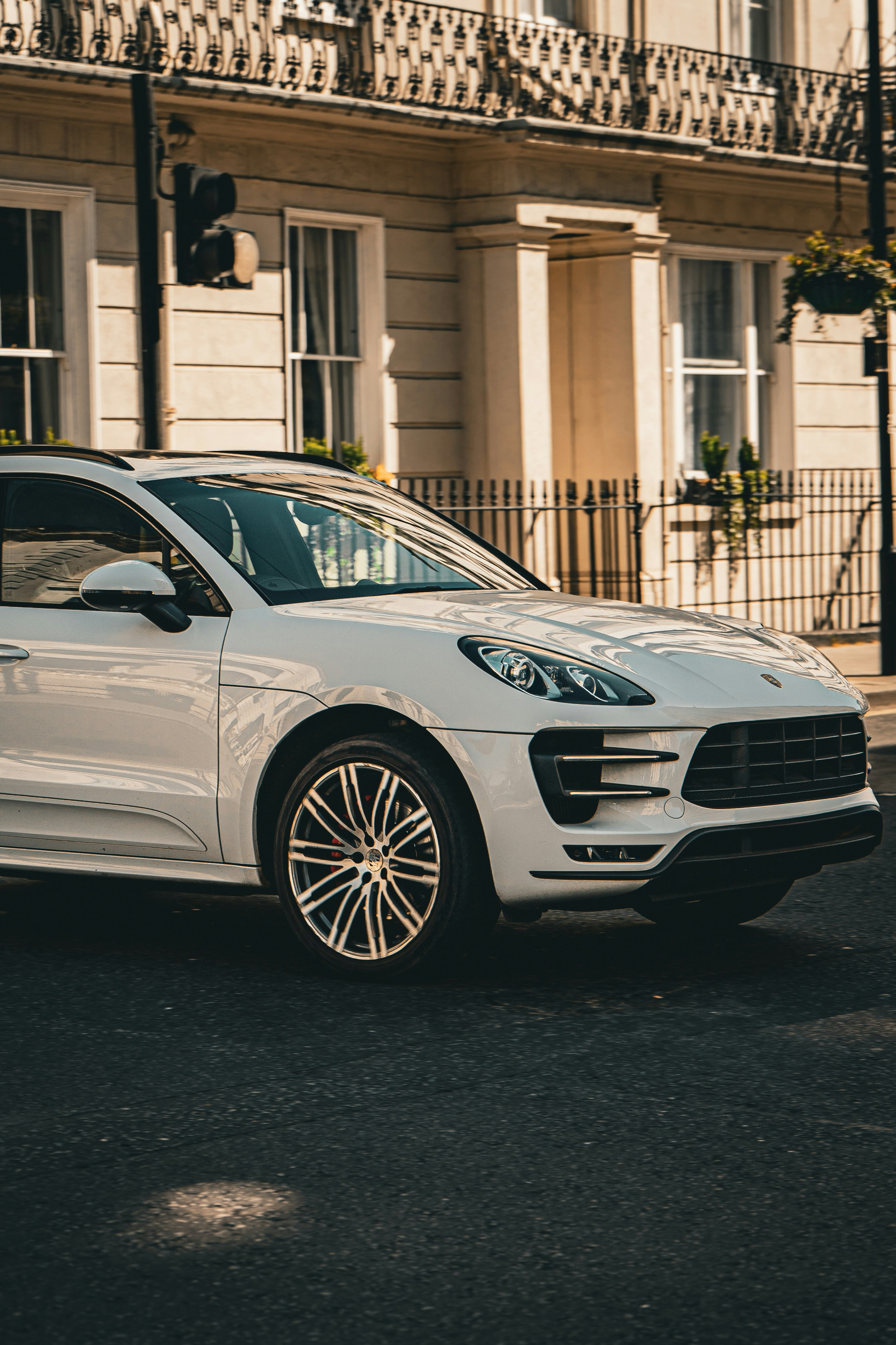 Sunlit White SUV Anchors a Quiet City Street by a Classic Townhouse