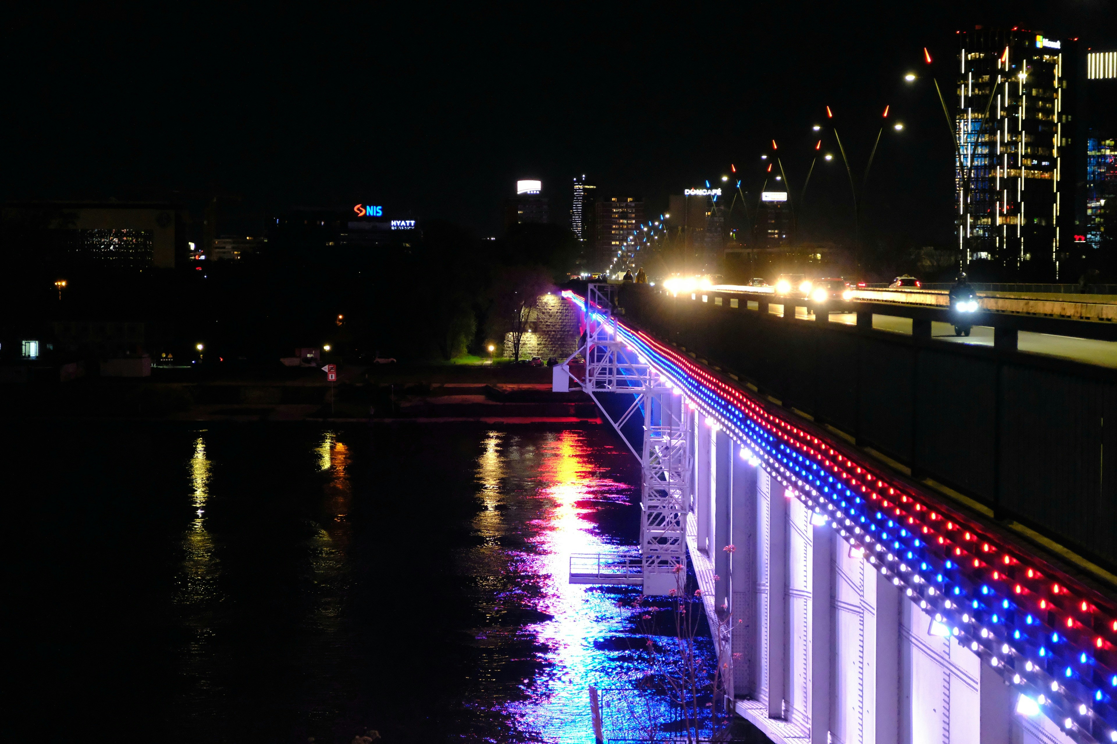 Neon Ribbon Bridge: Night Drive Along a Lit Waterfront