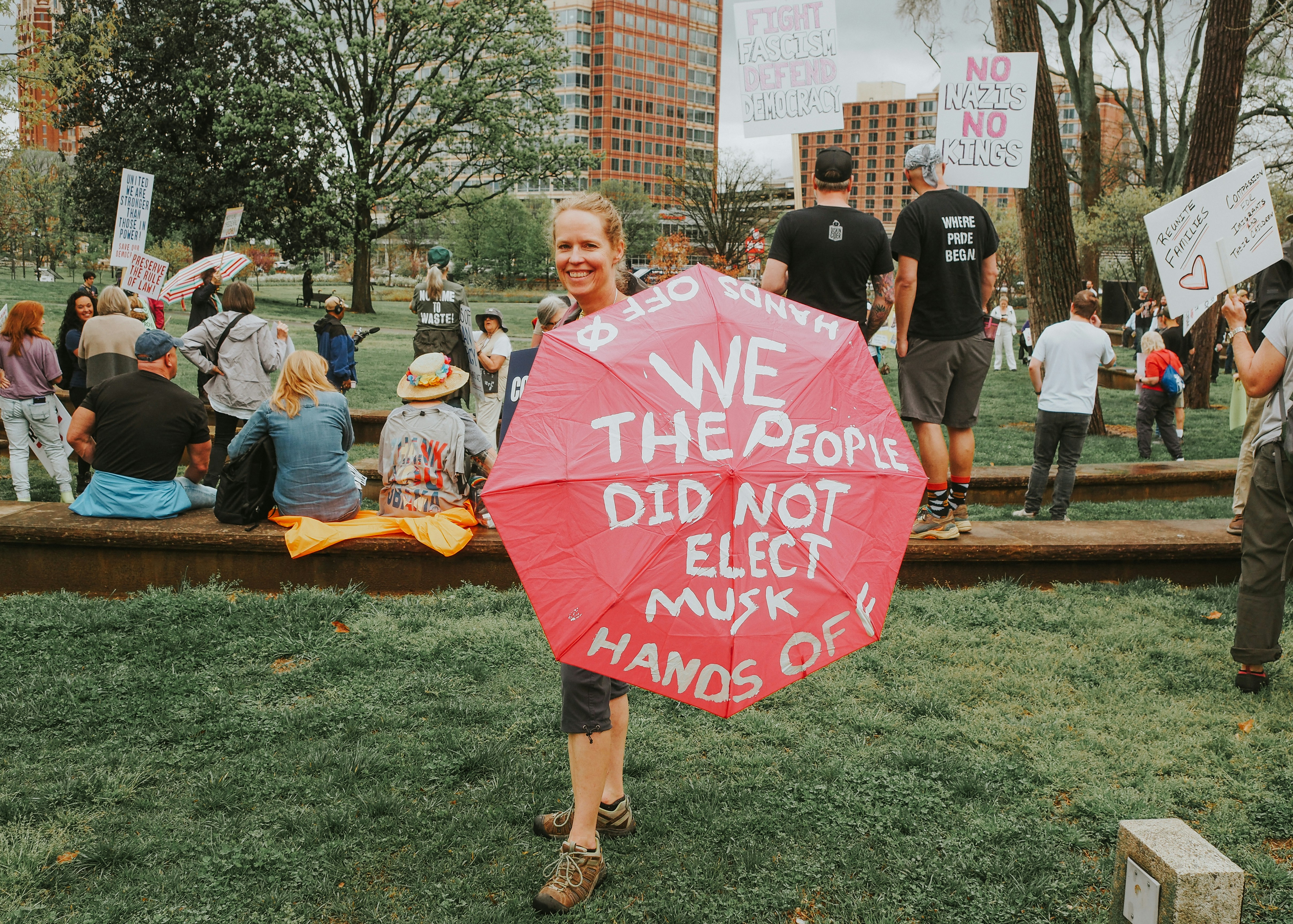 Protesters gather holding signs and an anti-musk umbrella. photo – Free ...