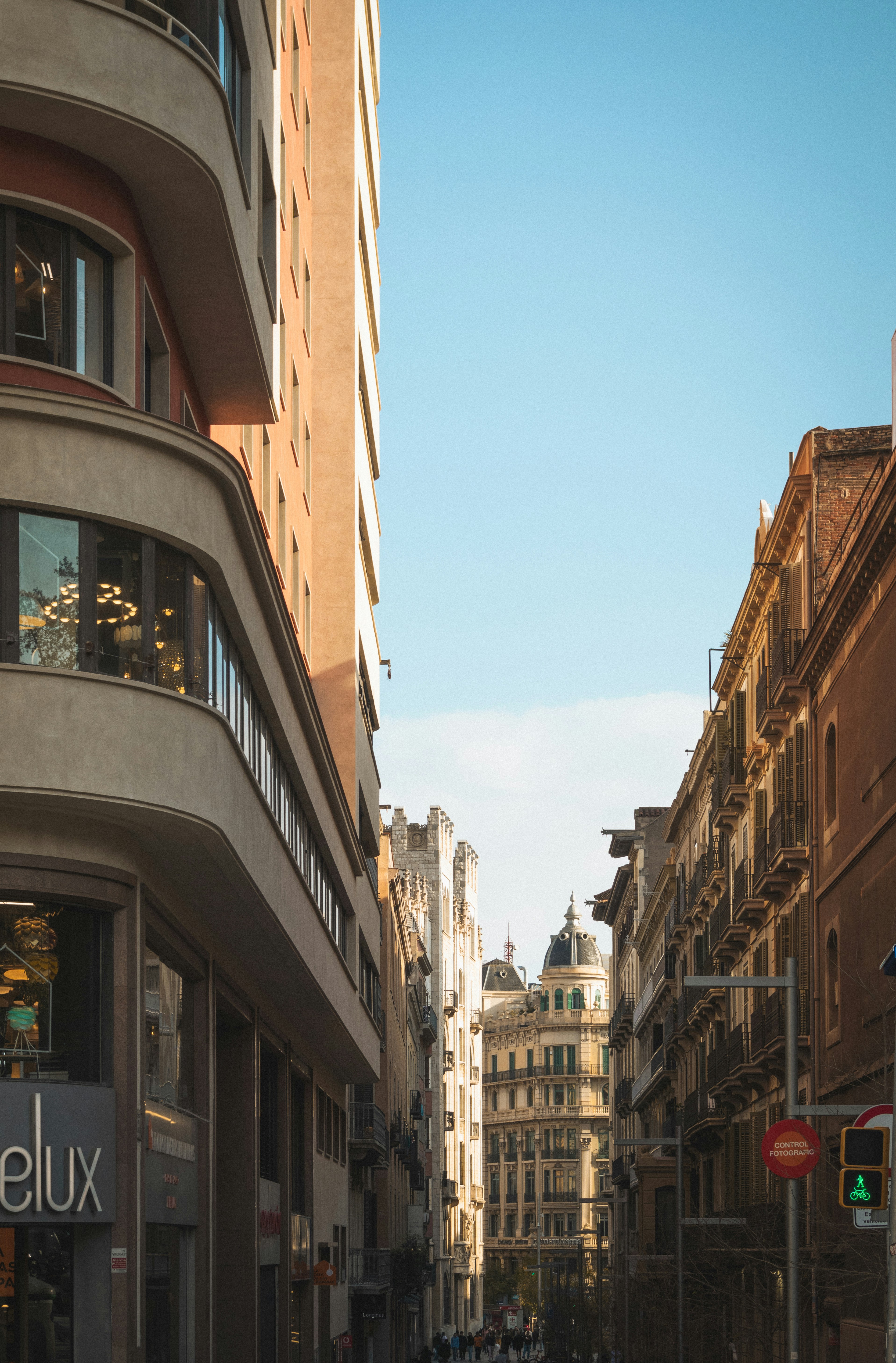 Buildings line a sunlit city street on a clear day.