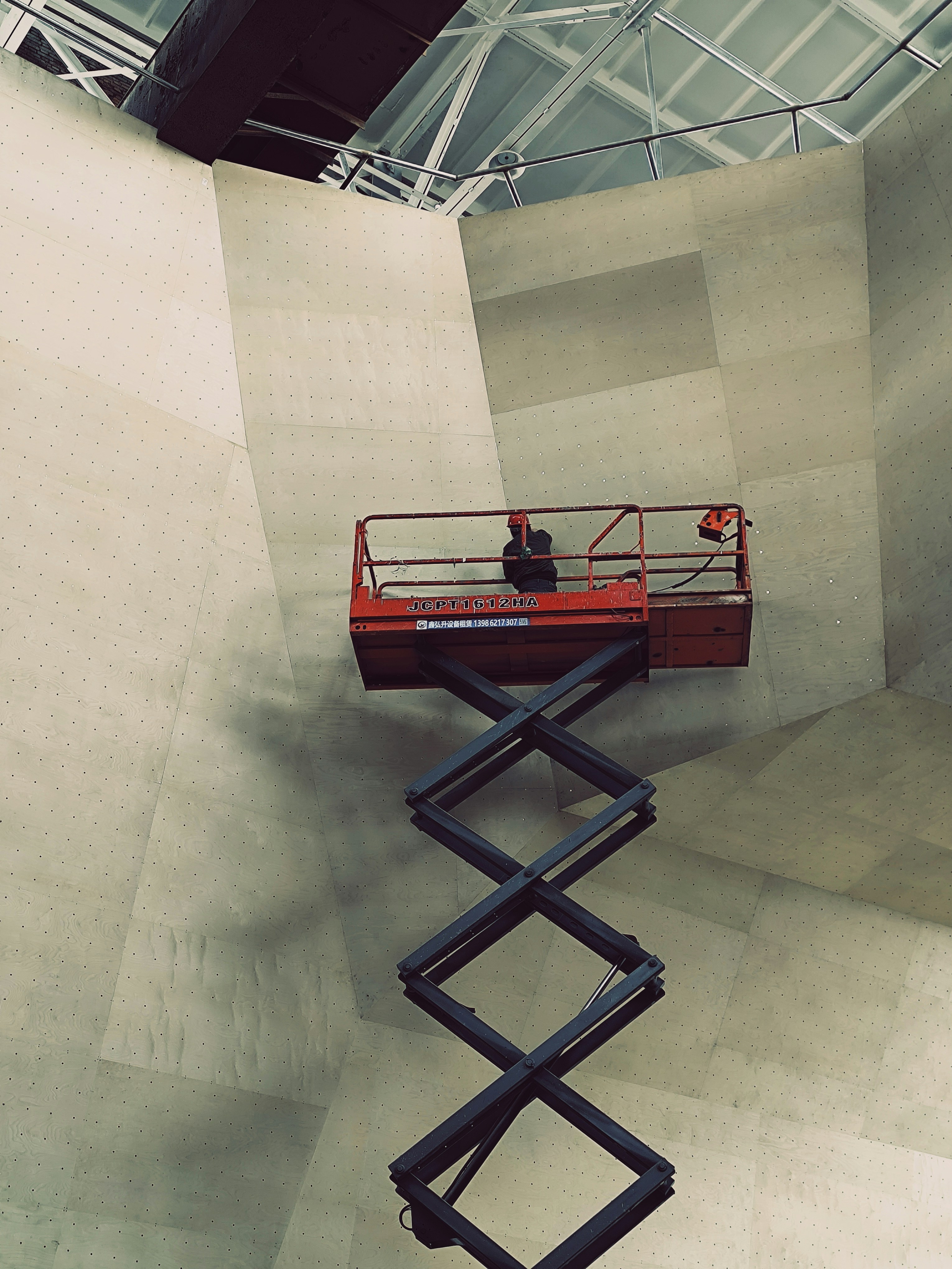 A worker uses a lift inside a large building. photo – Free Human Image ...