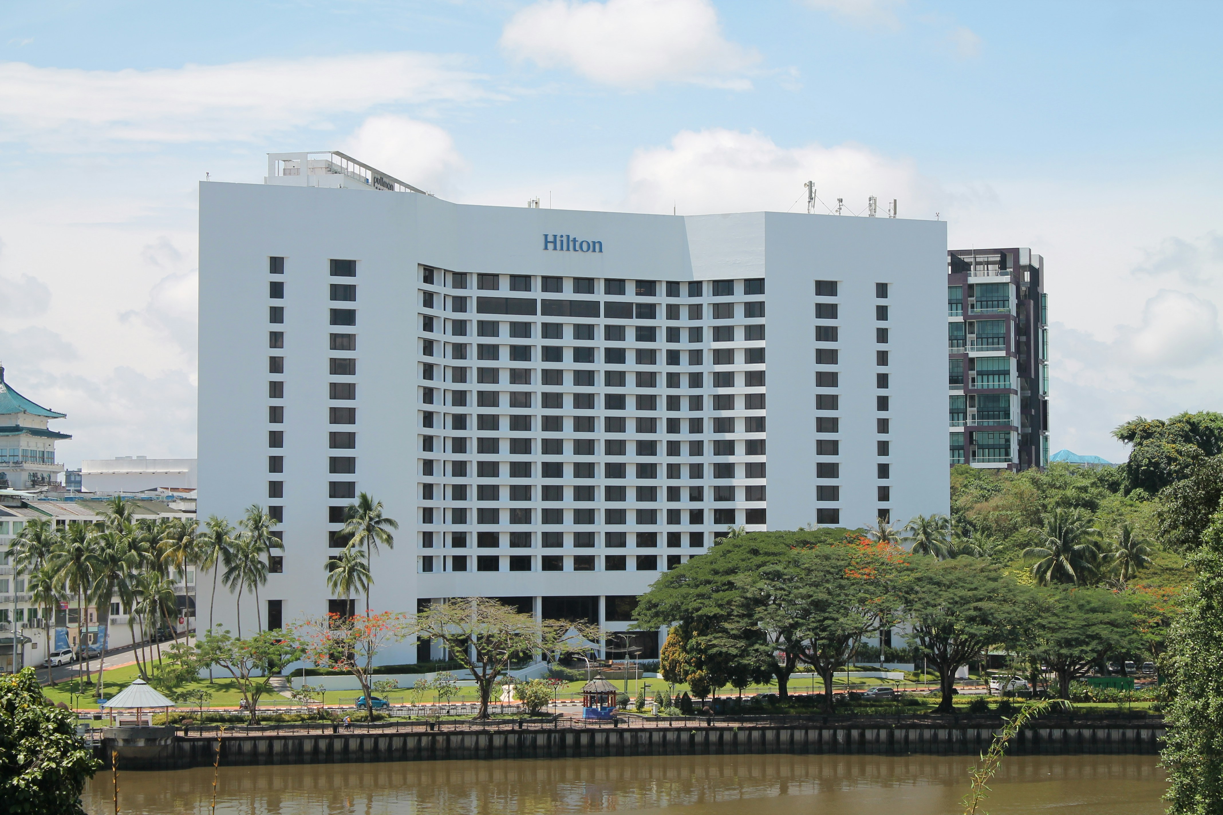 Here is a caption: the hilton hotel sits near the water. photo – Free ...
