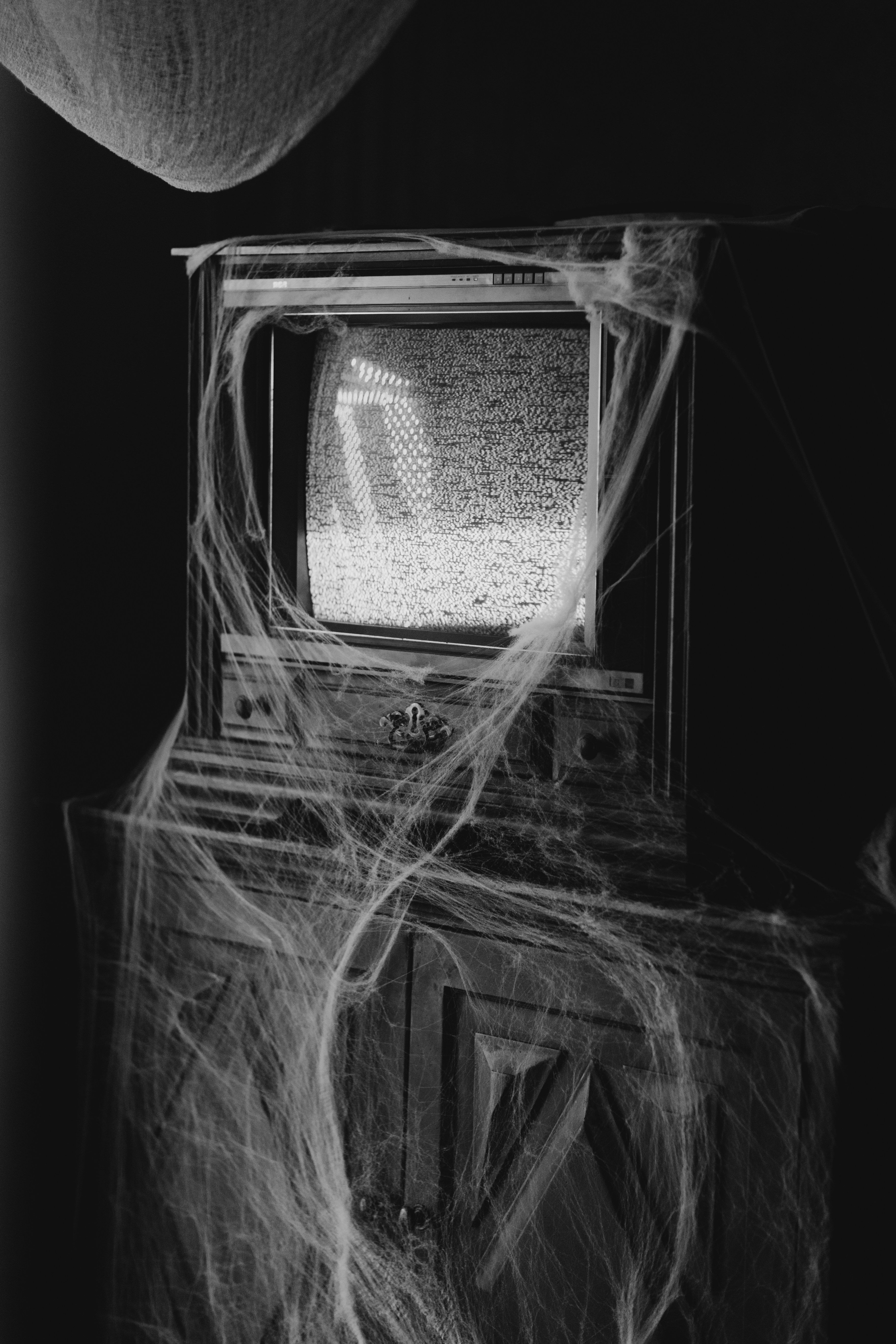 An old TV covered in cobwebs and static.