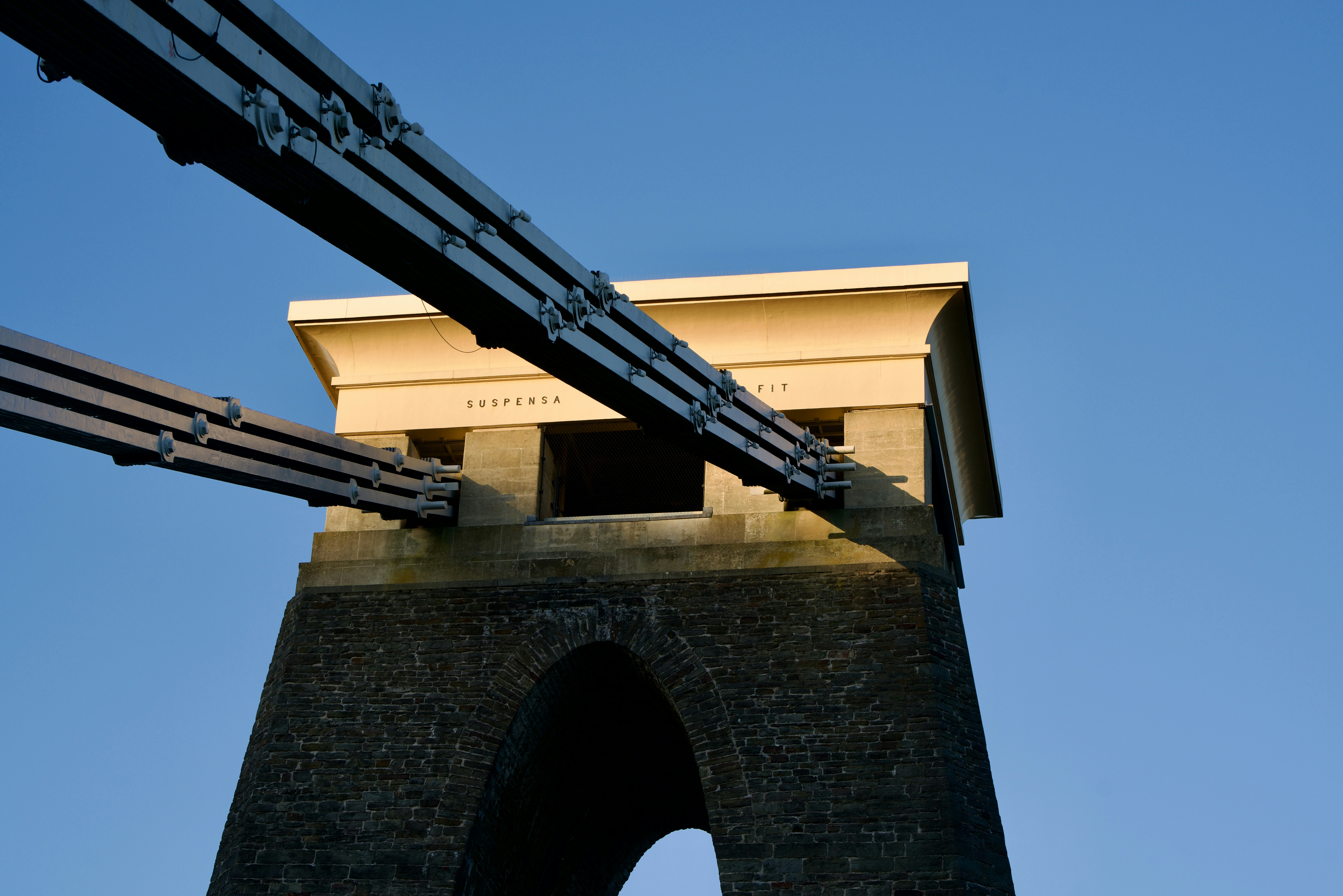 Steel Arcs over Stone Arch: A Bridge Tower Reaching Toward the Sky