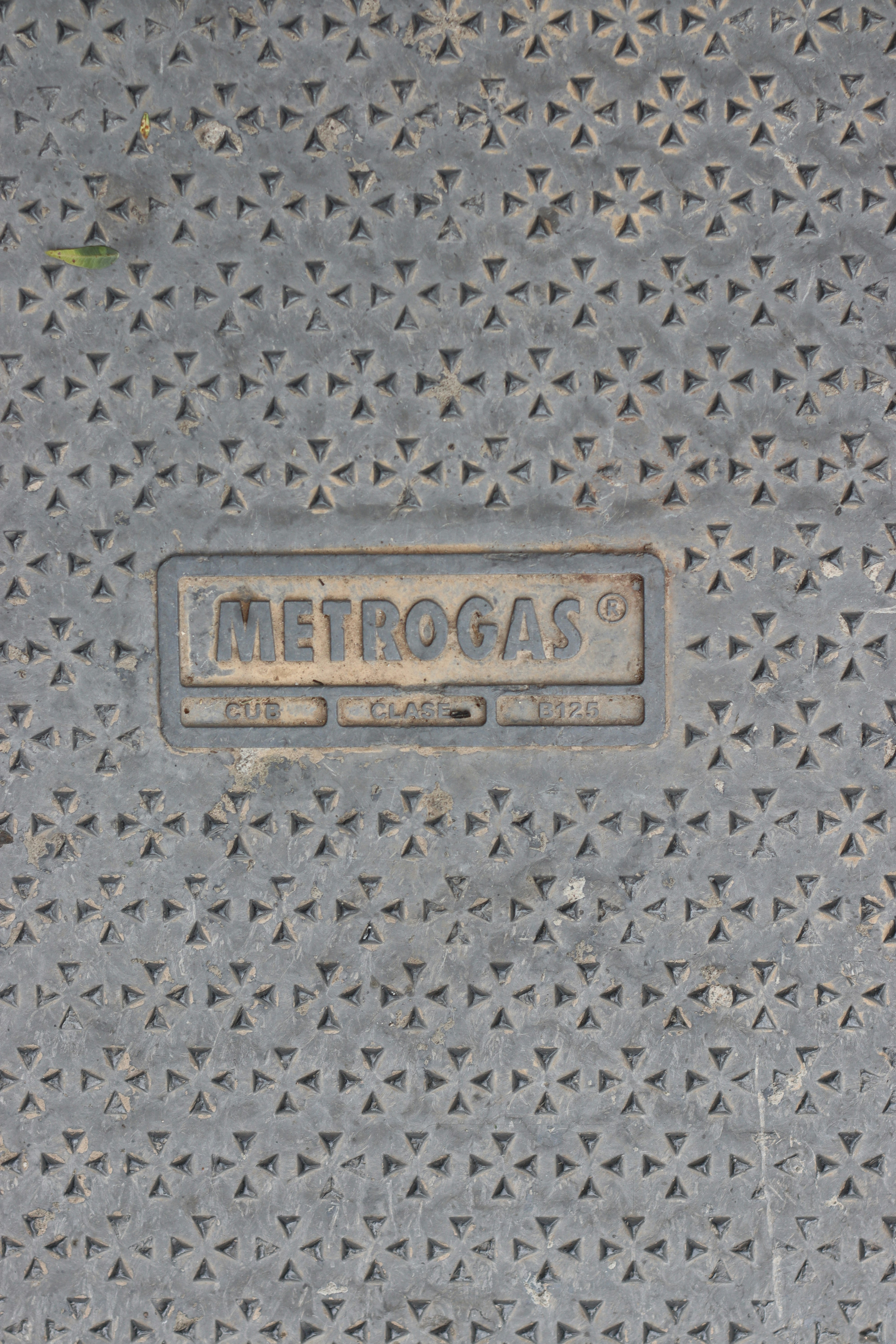 A manhole cover with the metrogas logo. photo – Free Texture Image on ...