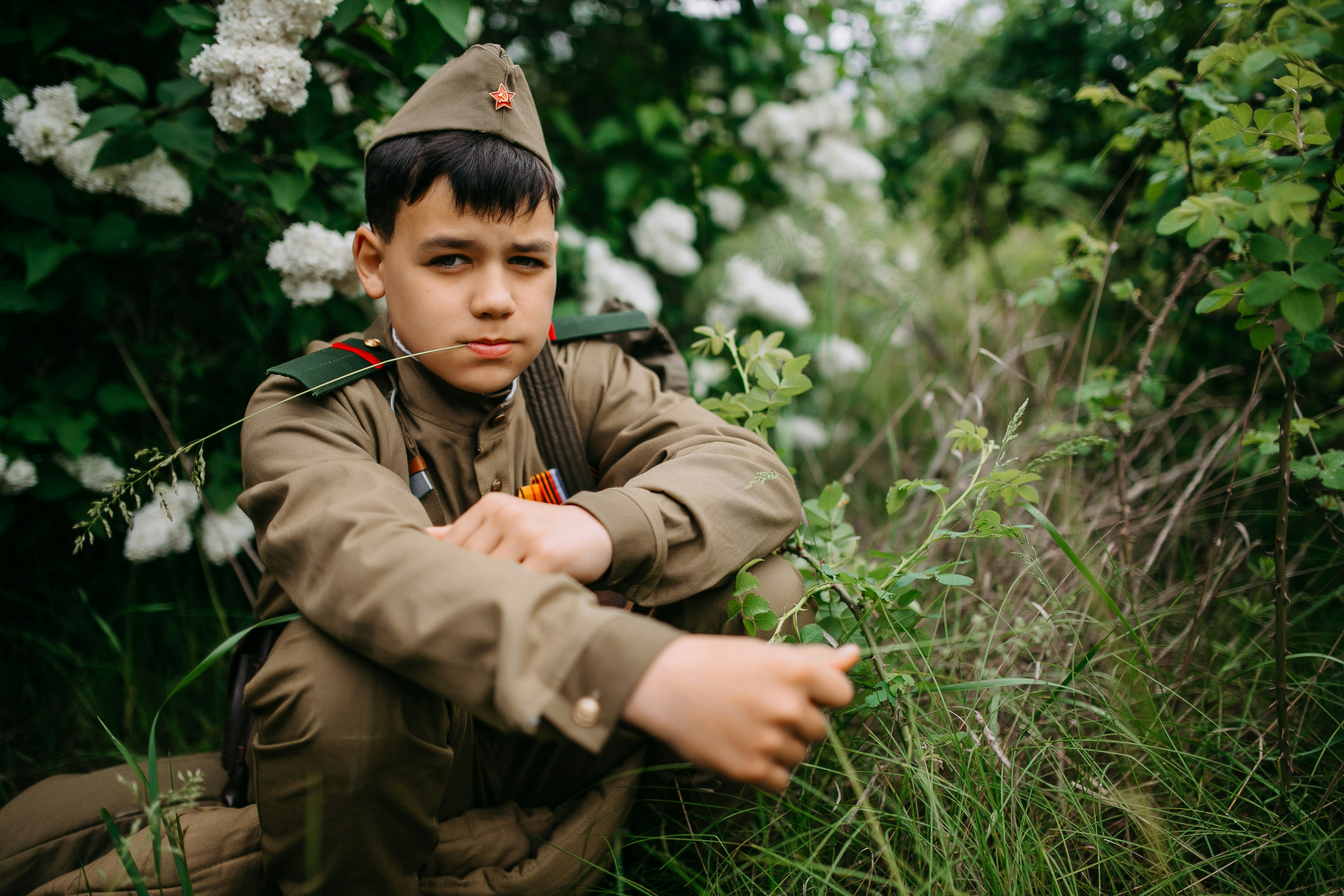 A young boy poses in a military uniform. photo – Free Human Image on ...