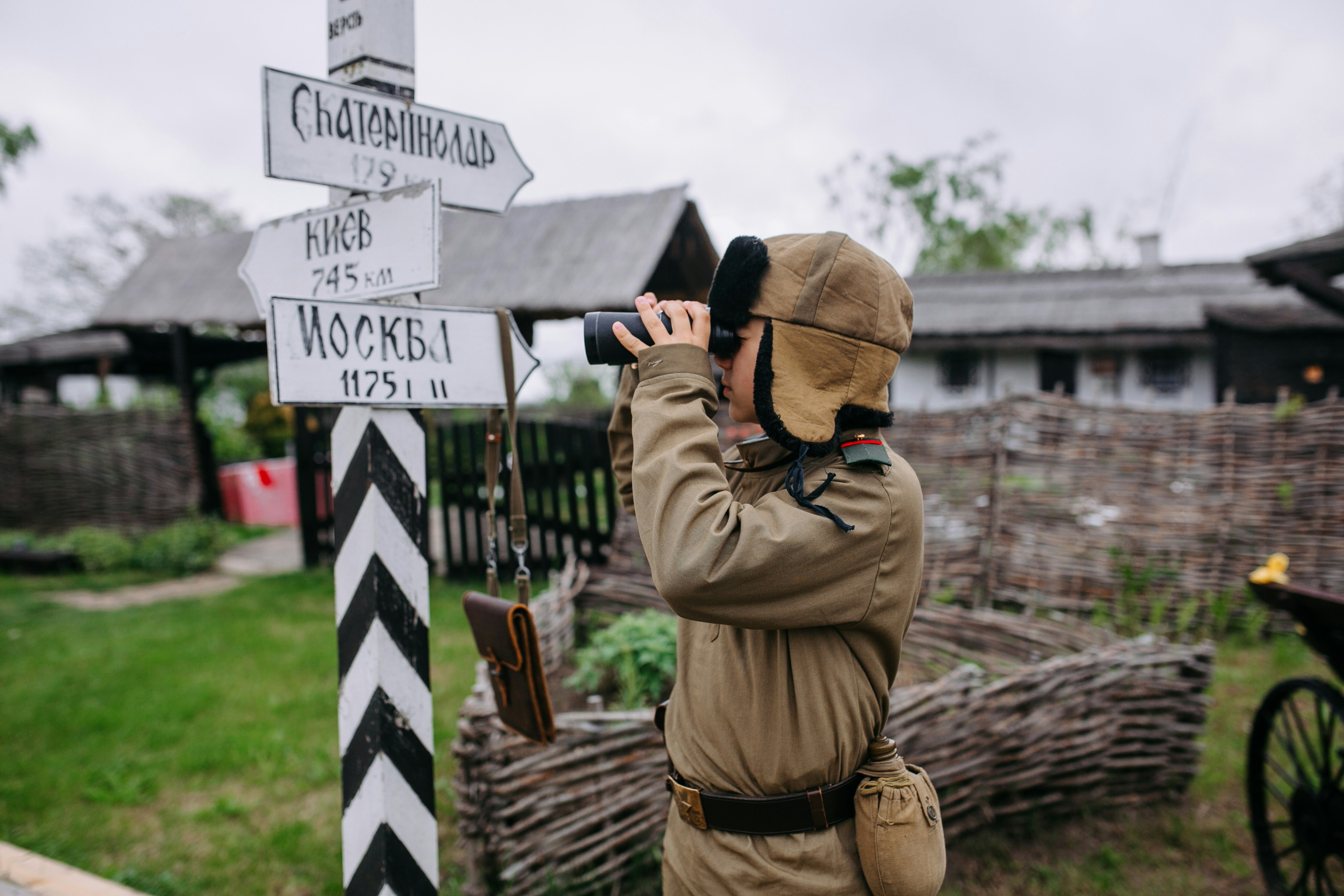 A child uses binoculars near a road sign. photo – Free Photo Image on ...