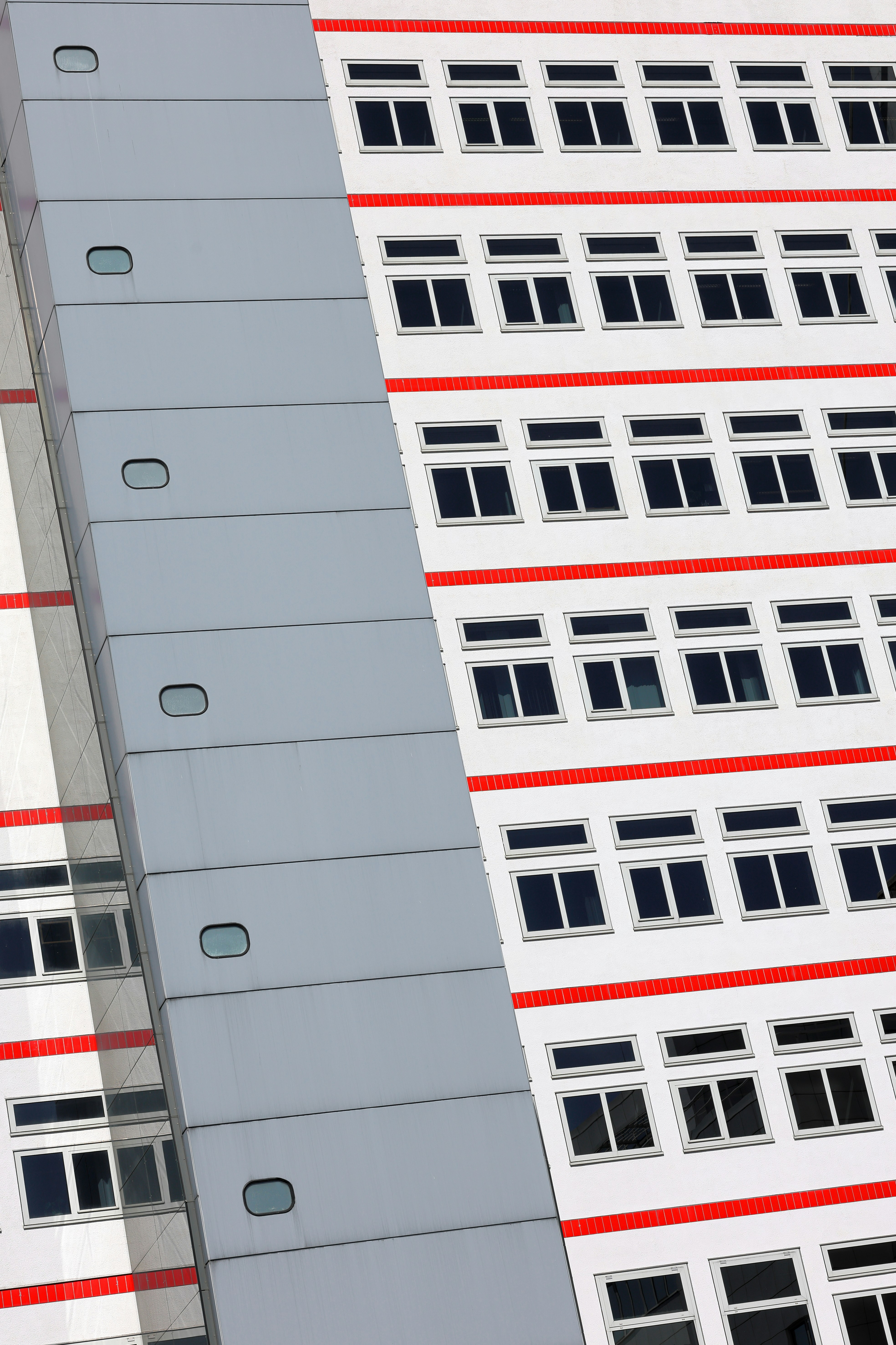 Fachada de edificio moderno con ventanas distintivas y líneas rojas ...